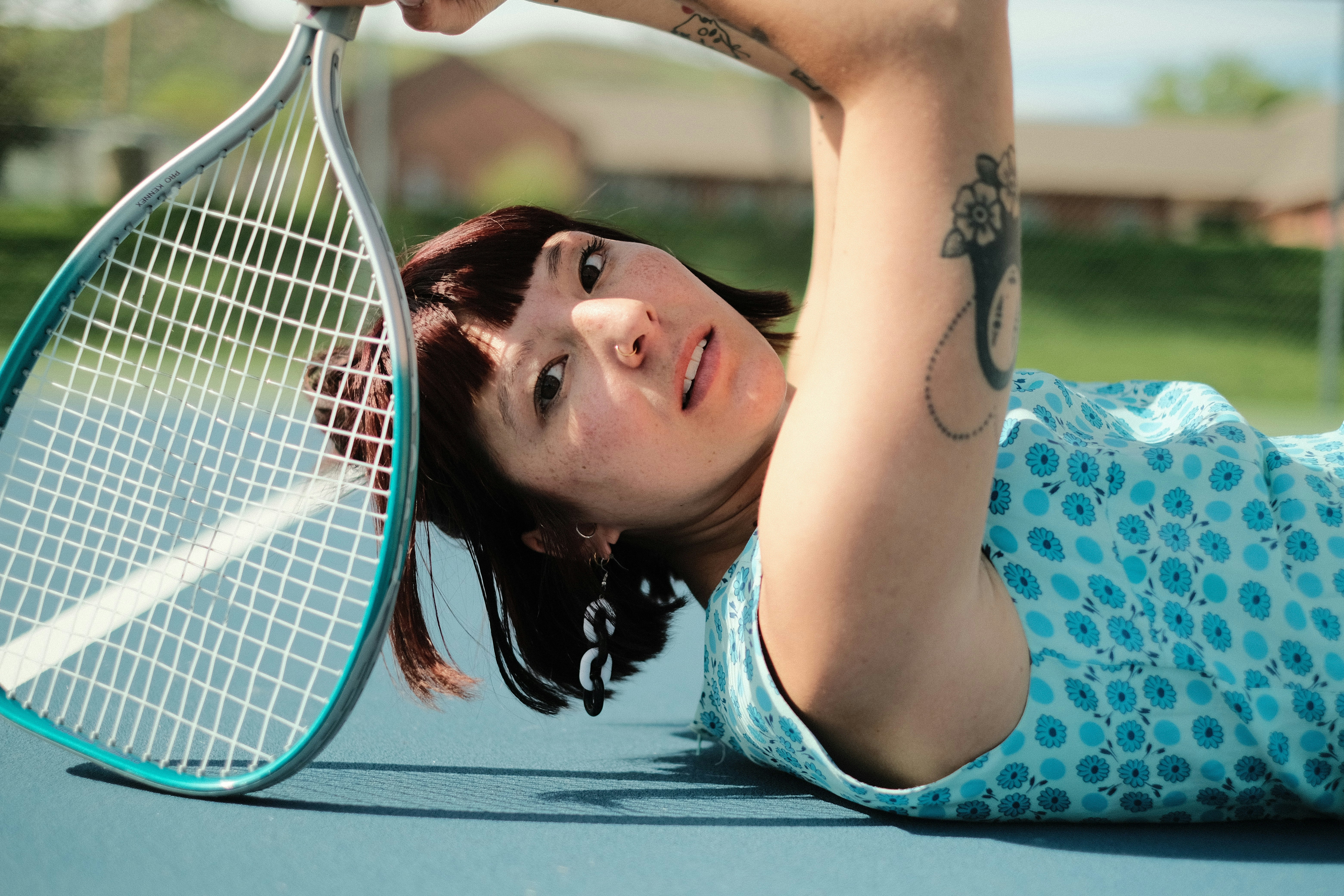 Eyes on the Serve: a relaxed tennis-court portrait with a tilted racket