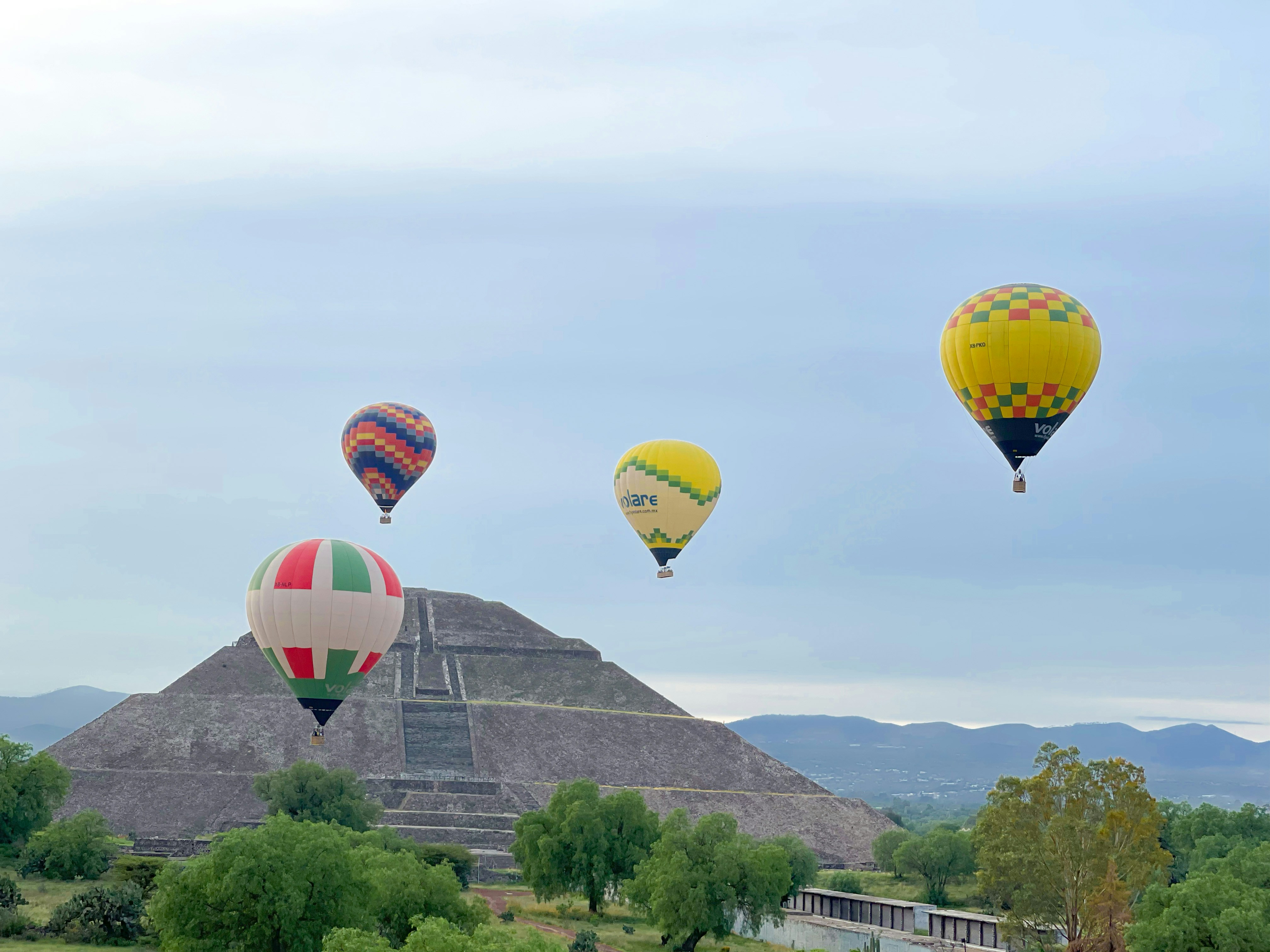 A group of hot air balloons flying over a pyramid photo – Free Balloon ...