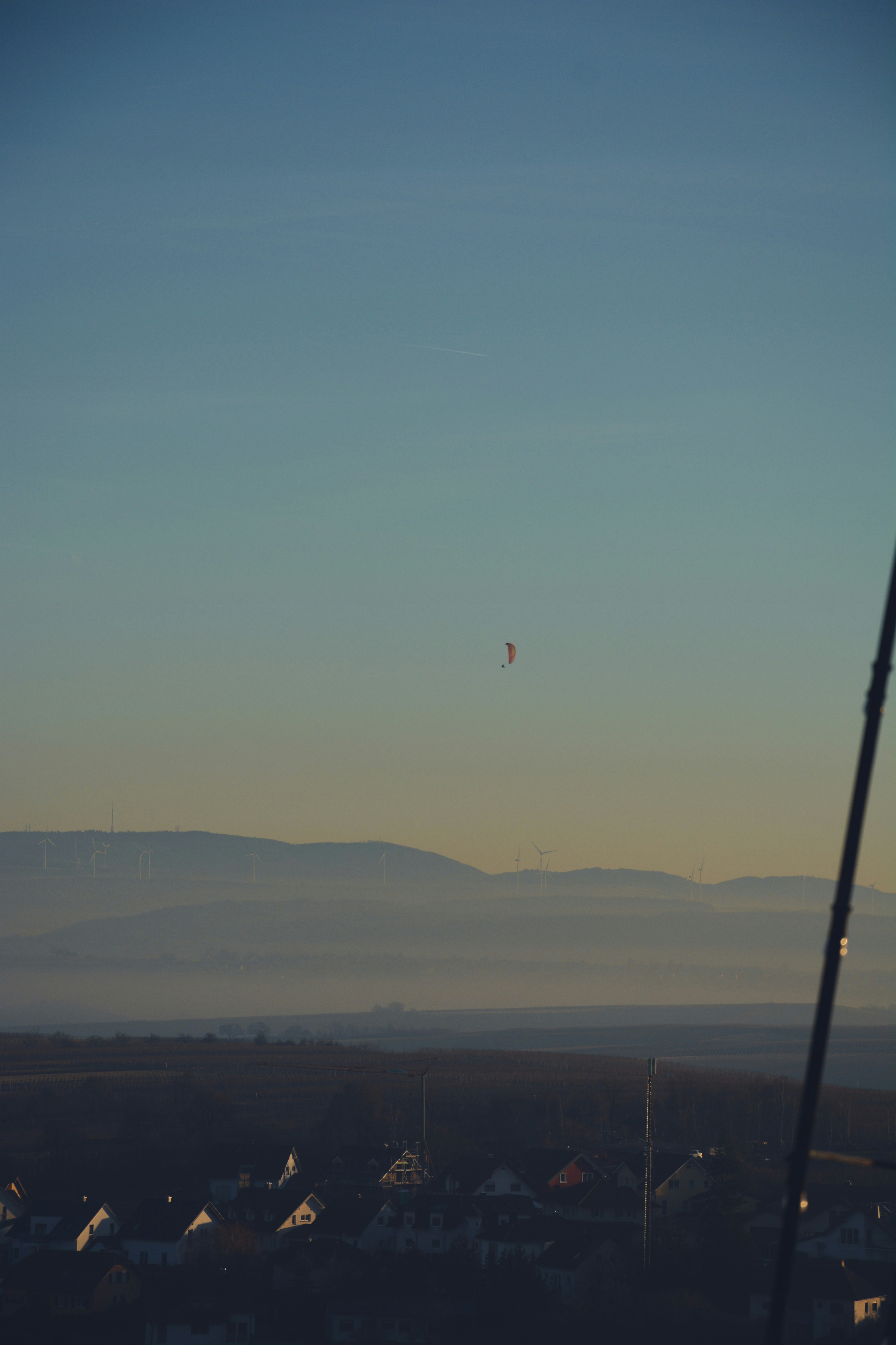 a kite flying in the sky over a town