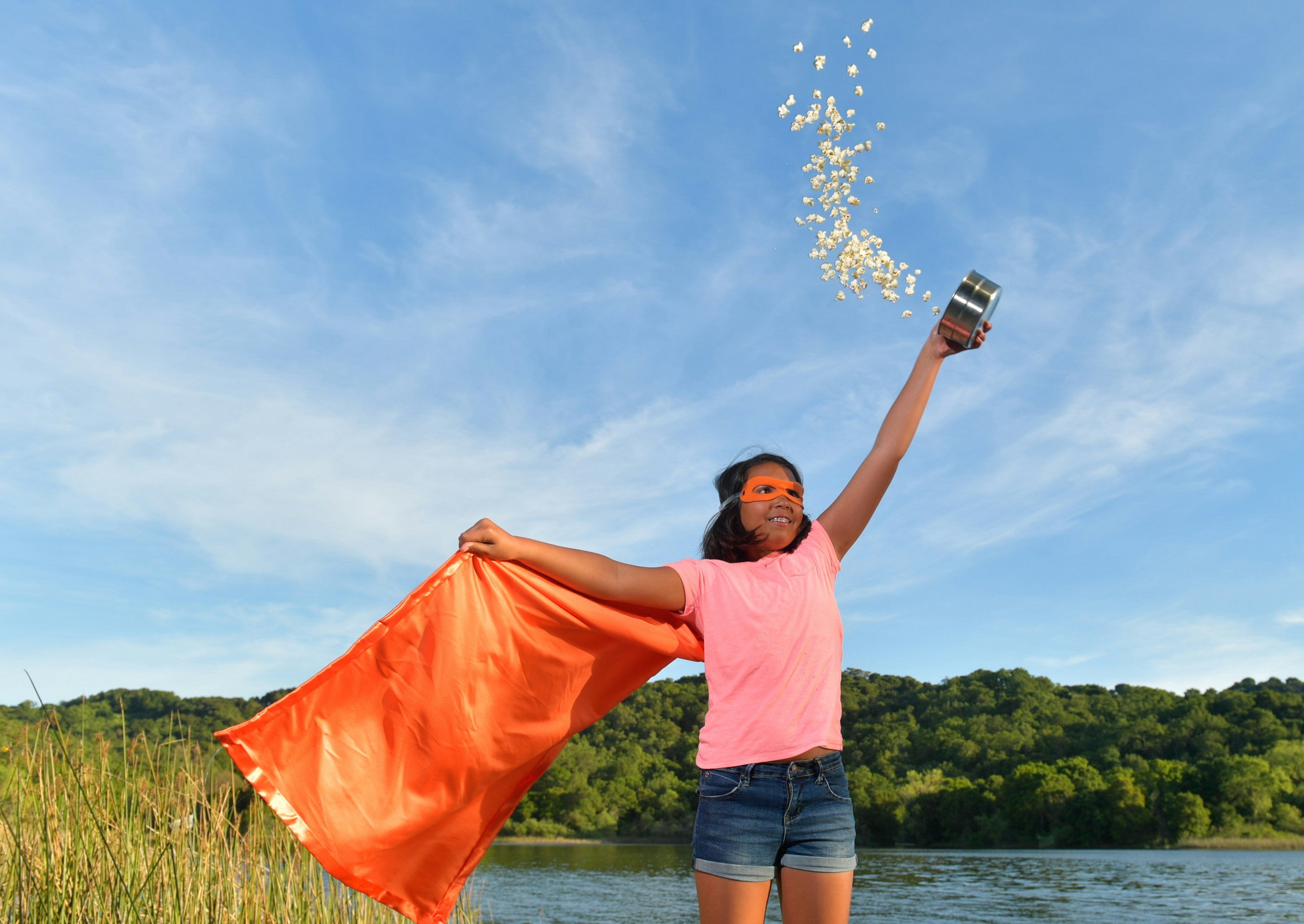 Joyful spray: a girl fans sparkles over a lakeside celebration