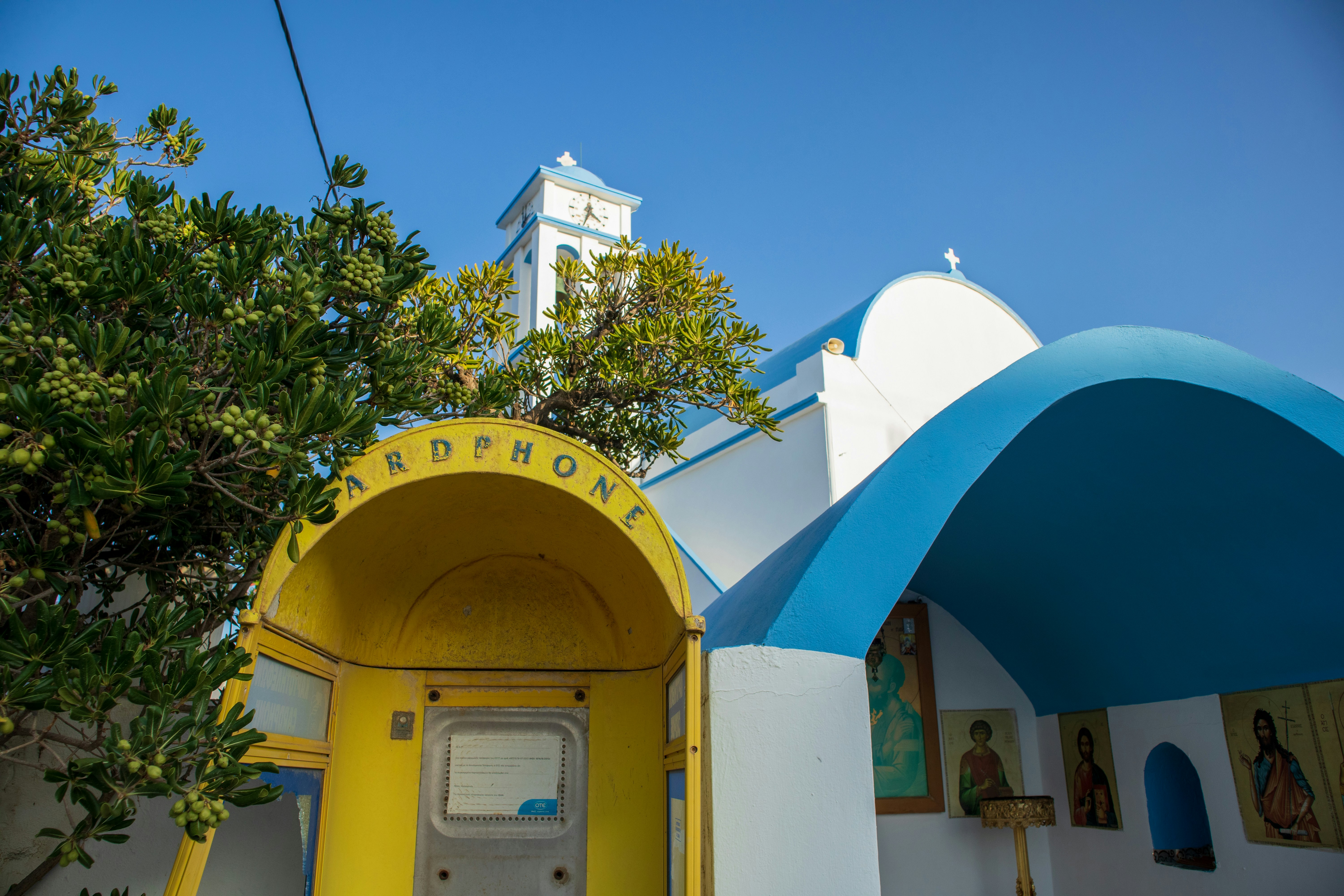 Arched Blue Roof Saint’s Courtyard and a Bright Yellow Public Phone Booth