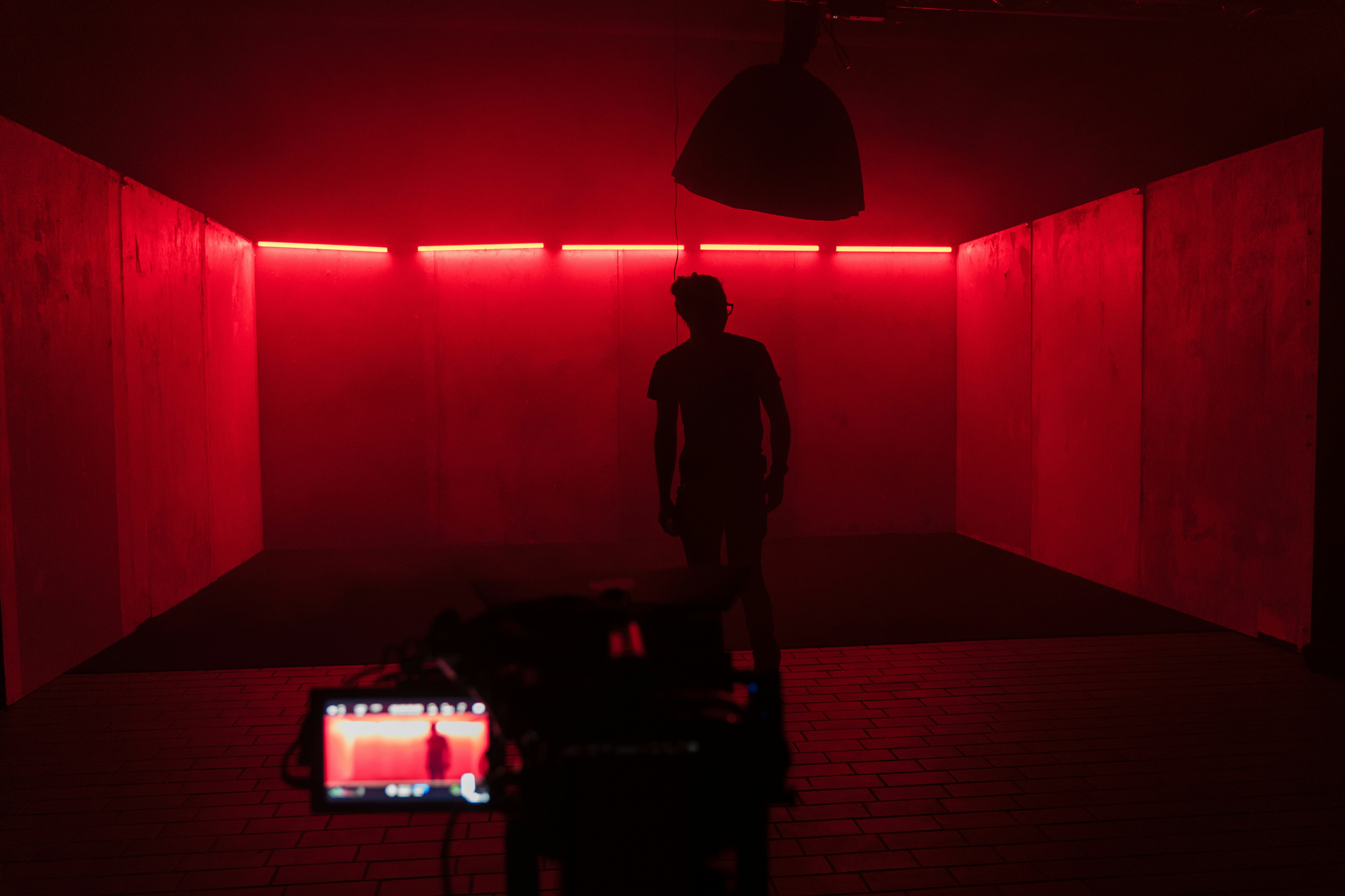 A man standing in a dark room with a red light photo – Free Dortmund ...