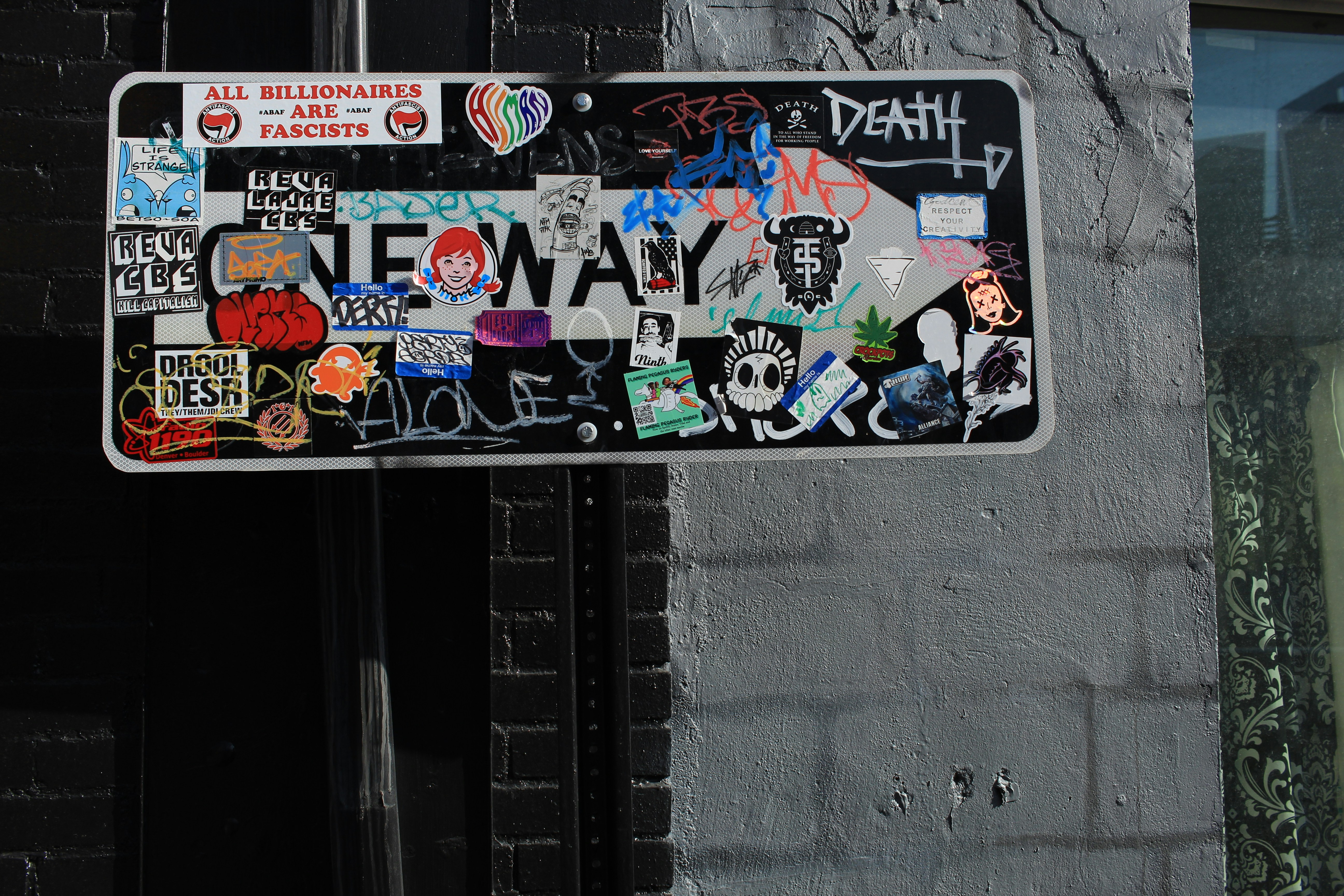 A street sign covered in lots of stickers photo – Free Street ...