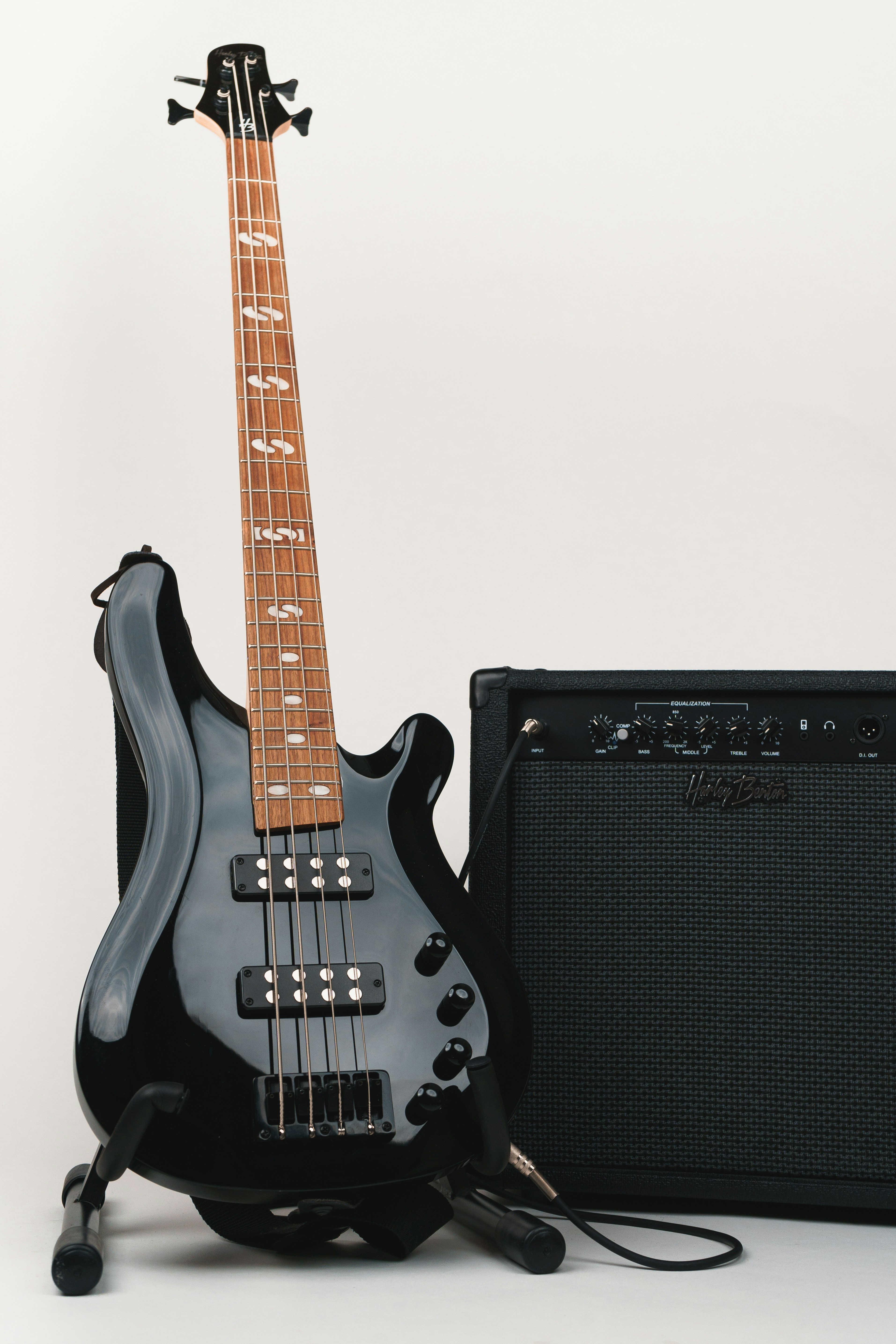 A sleek black bass guitar stands elegantly next to a compact amplifier, showcasing a perfect blend of form and function.