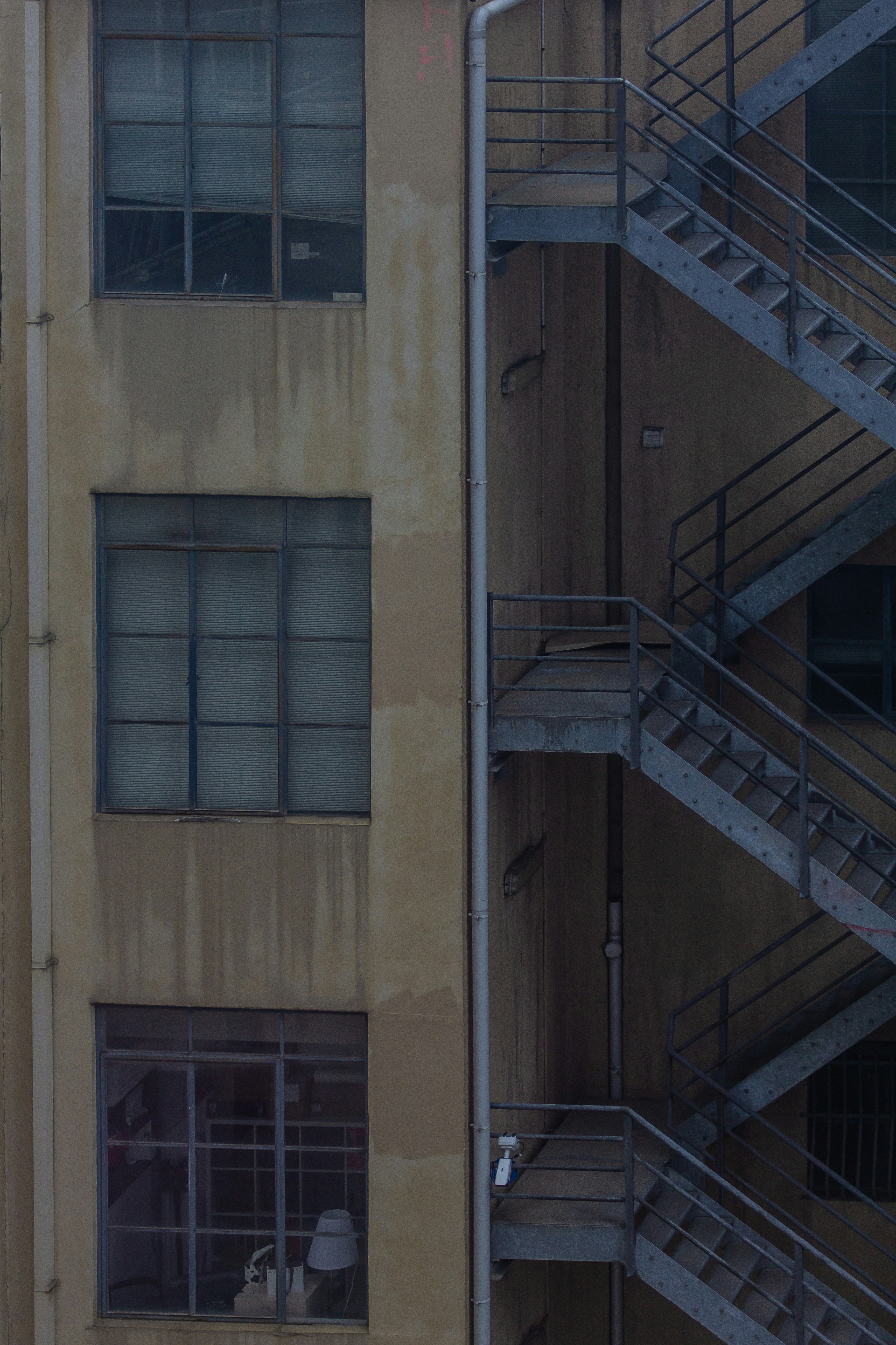 Vertical Echoes: Windows, Staircase, and Weathered Facade