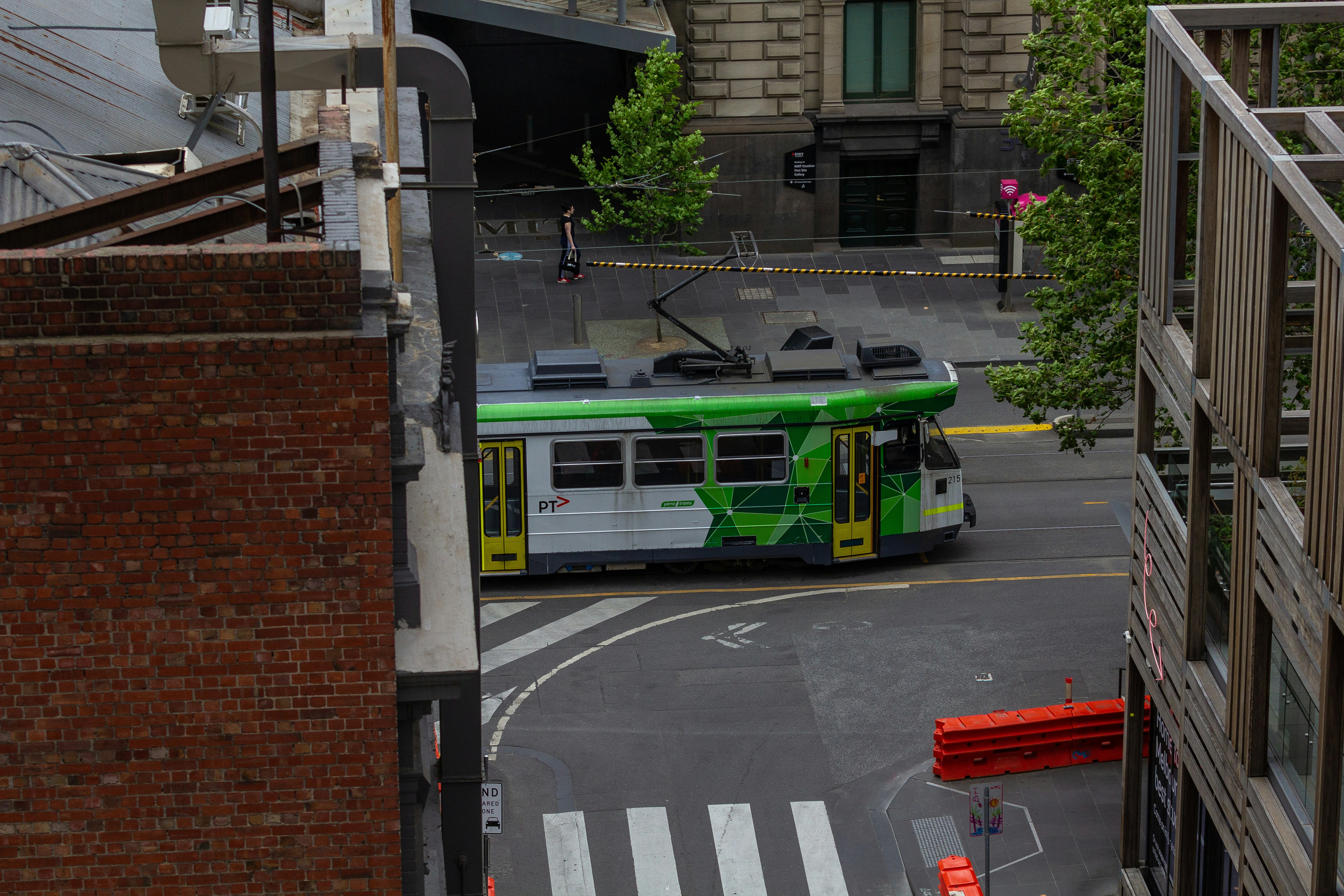 A green and yellow bus driving down a street photo – Free Melbourne ...