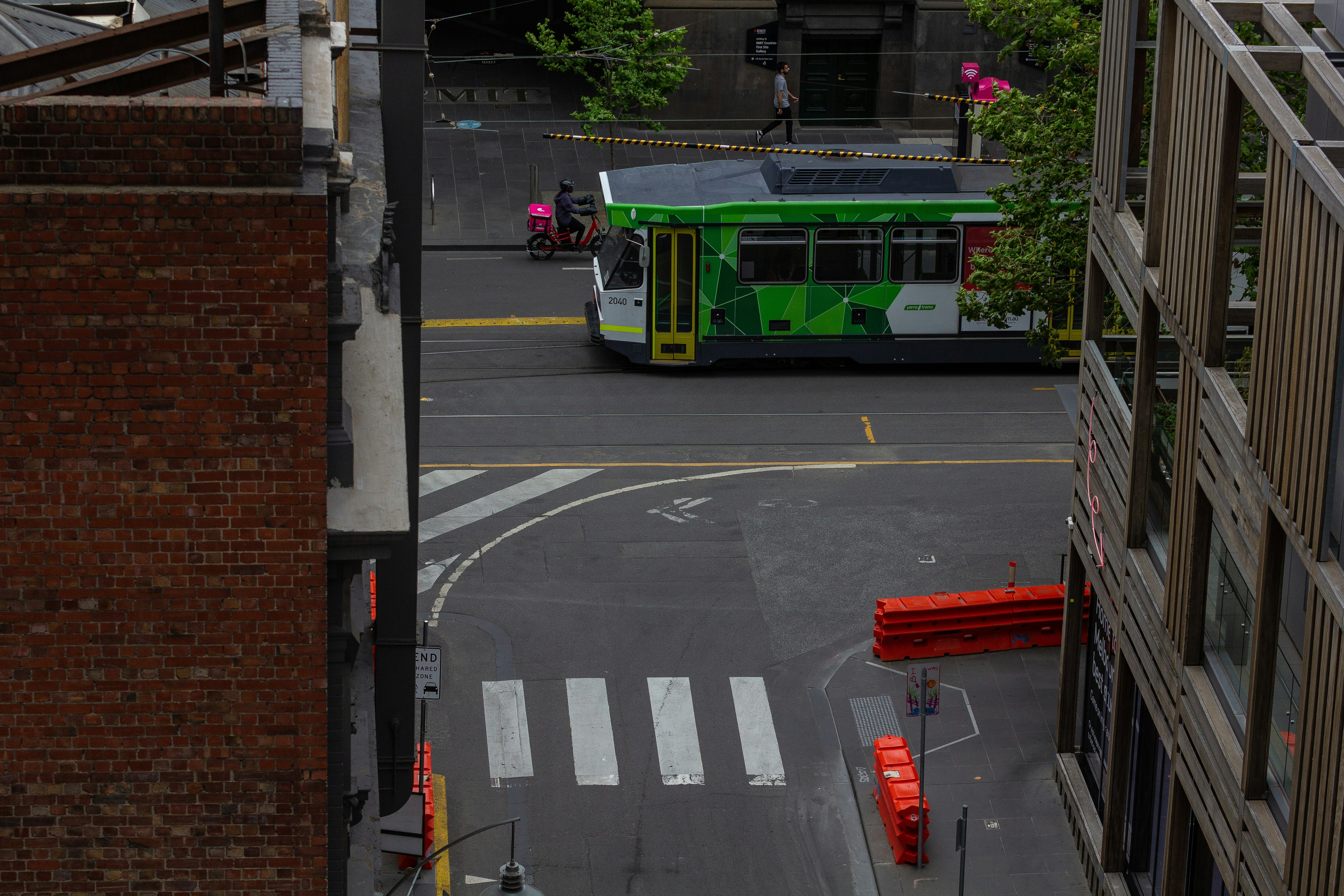 Foto Un autobús verde conduciendo por una calle junto a edificios altos ...
