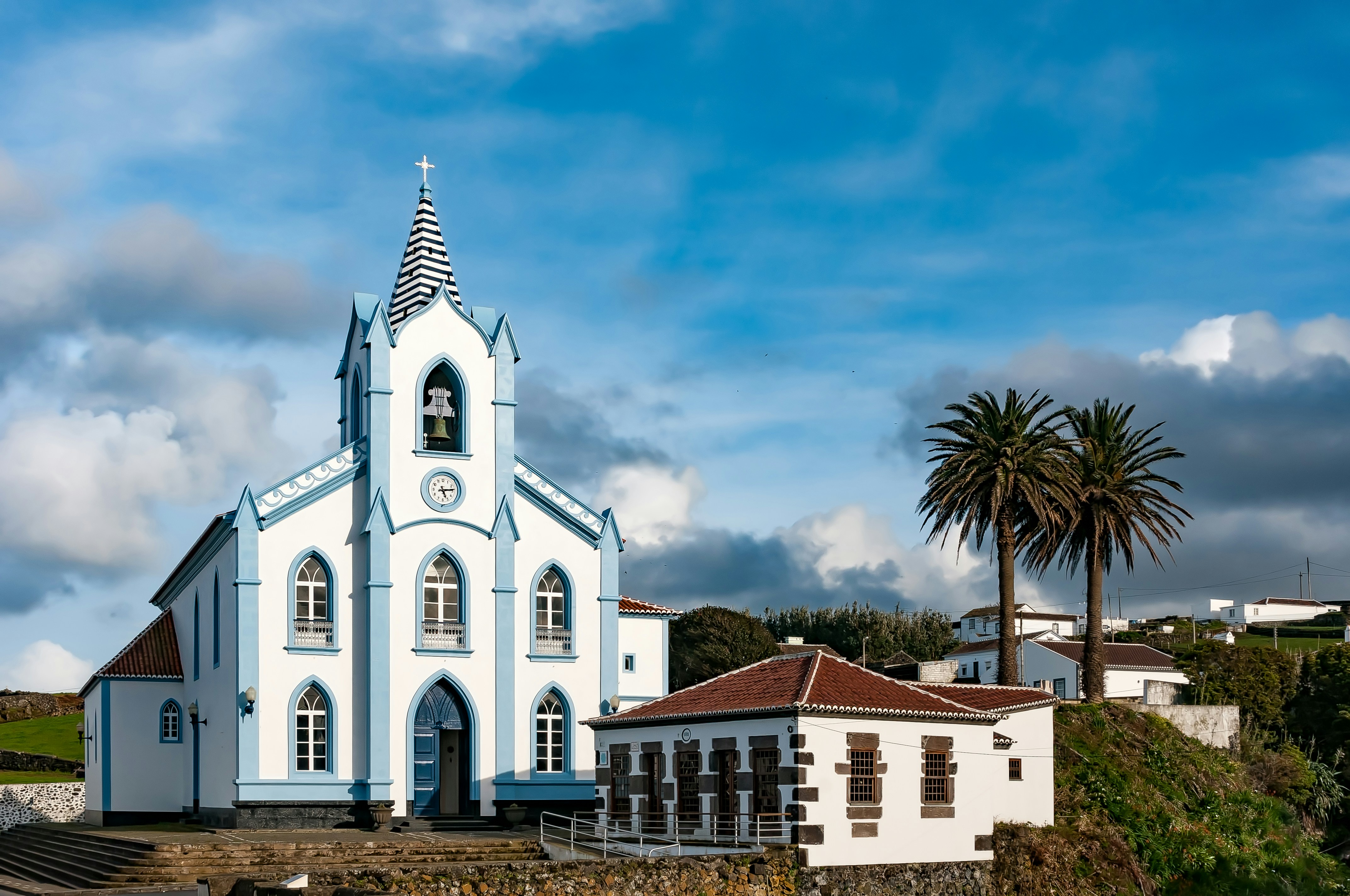A blue and white church with palm trees in the background photo – Free ...