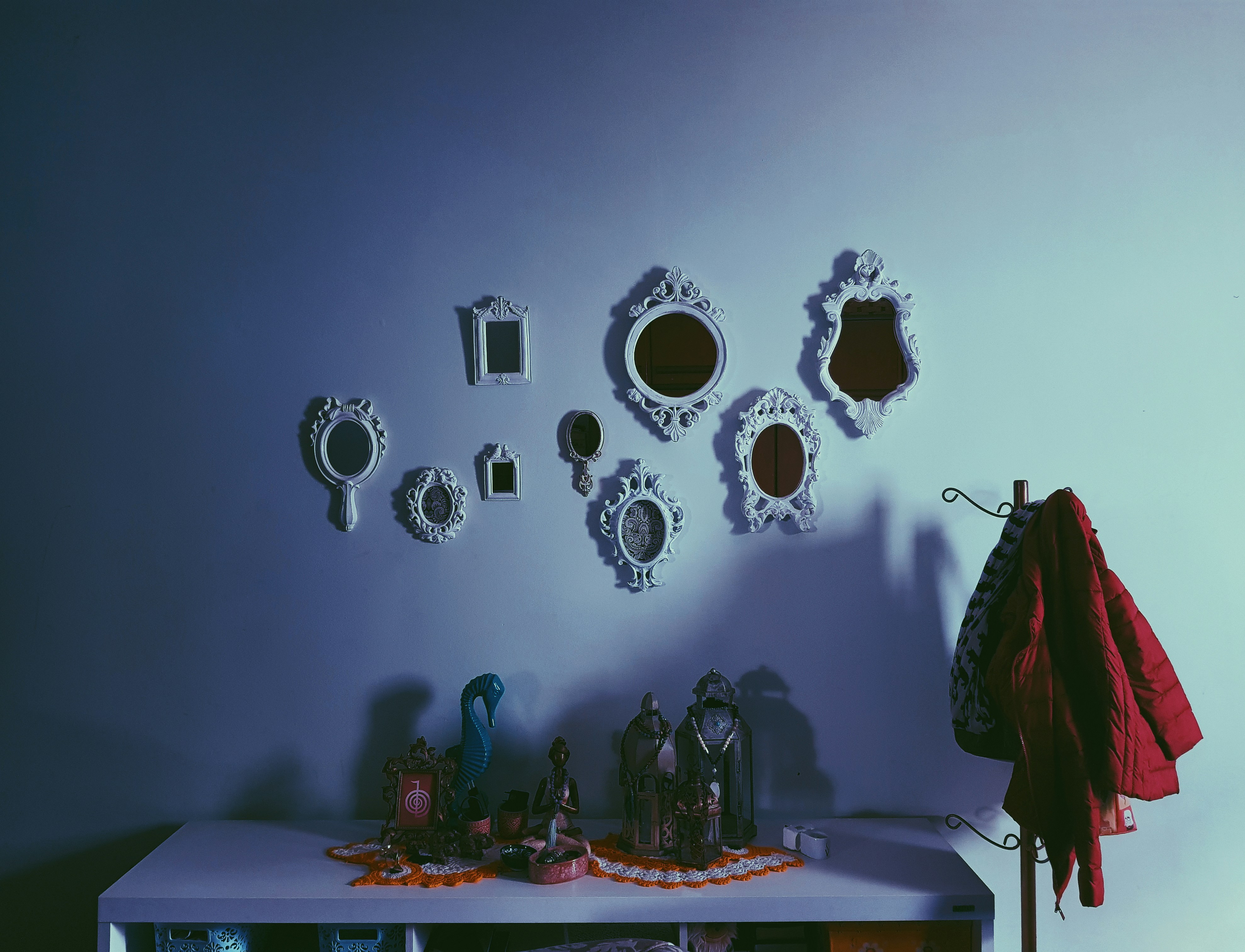 Curated silhouettes: a wall of ornate mirrors above a dresser