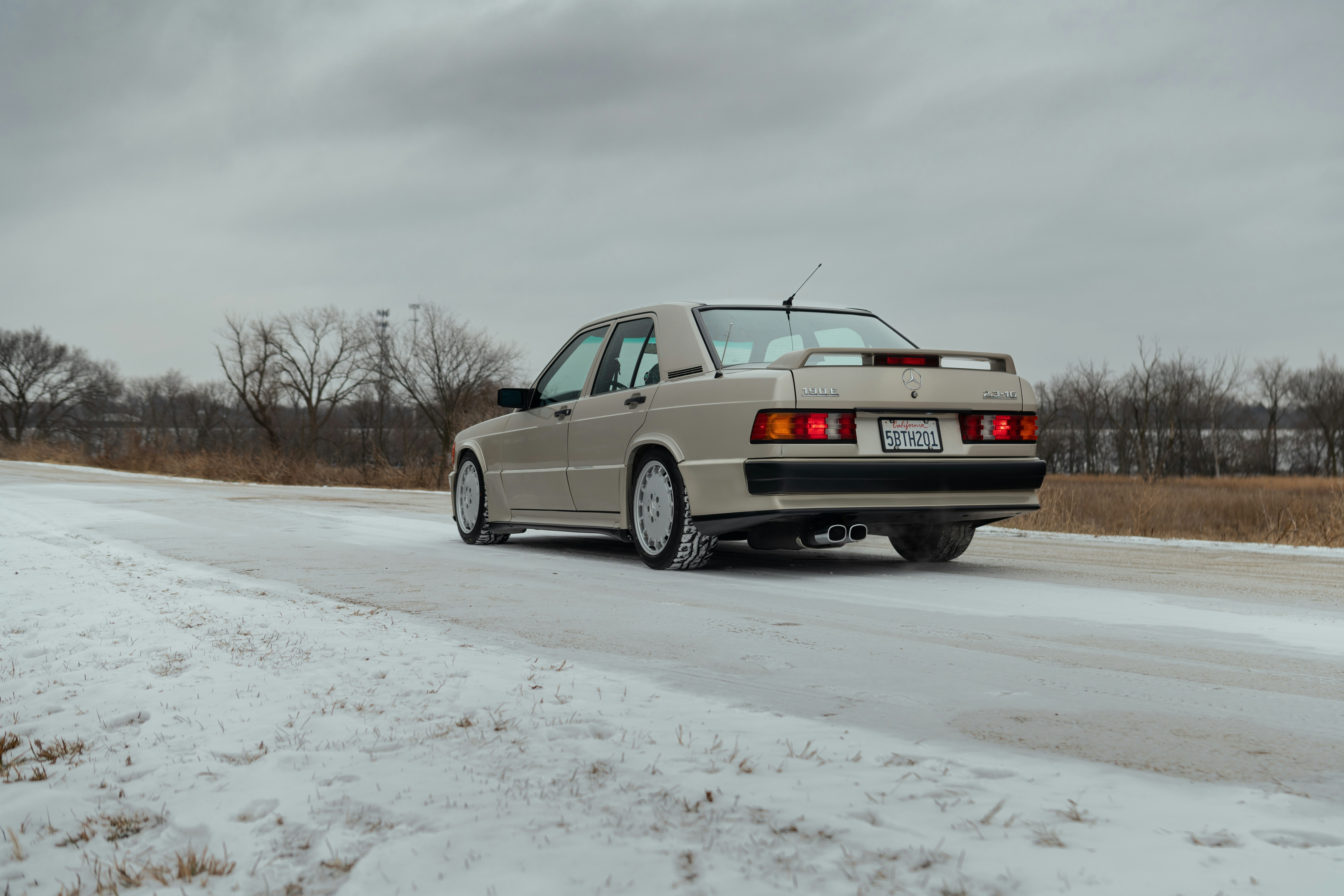 A beige car driving down a snow covered road photo – Free Automotive ...