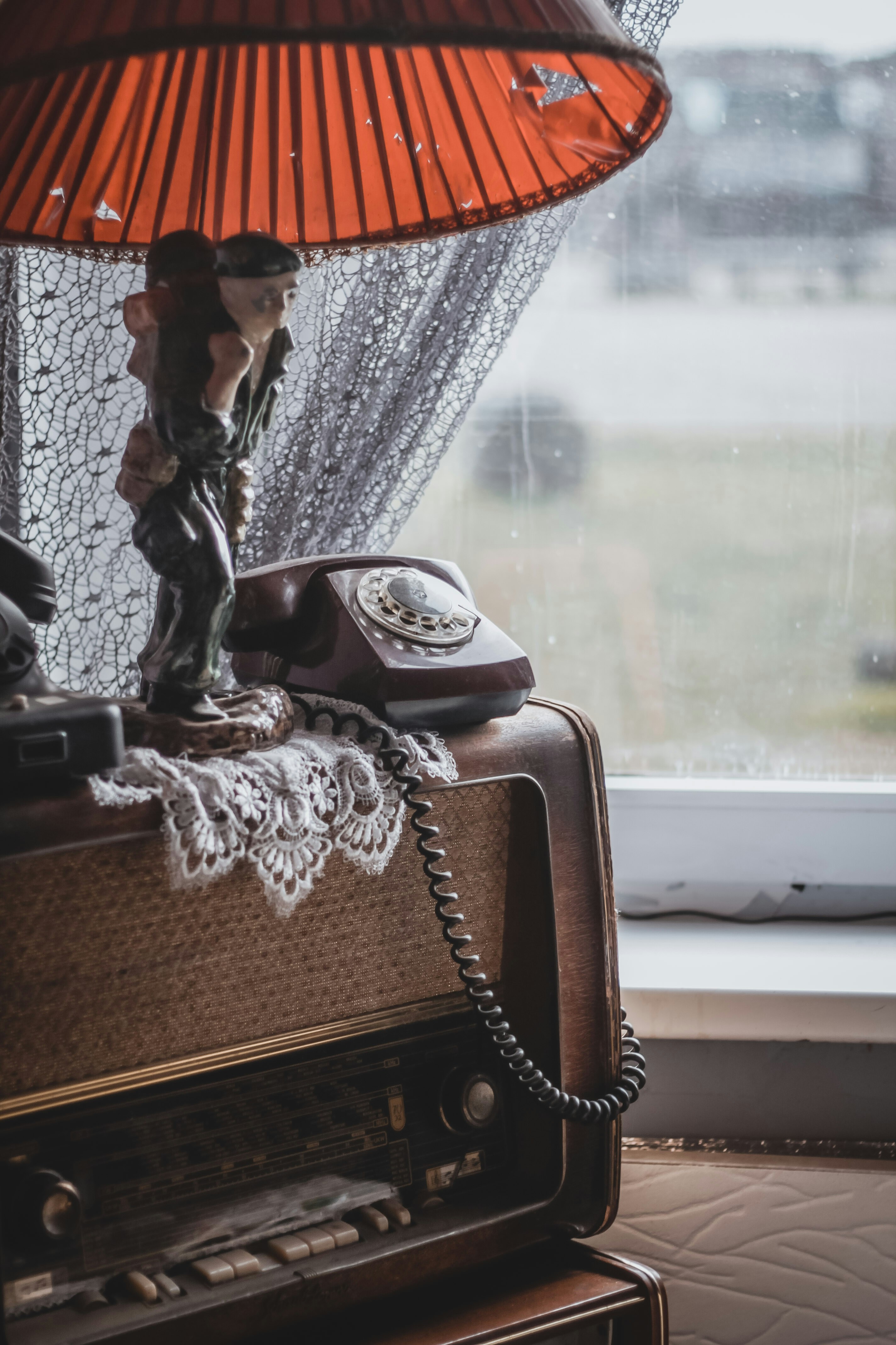Lace, Lantern, and Rain: A Tiny Figurine Guards a Vintage Radio