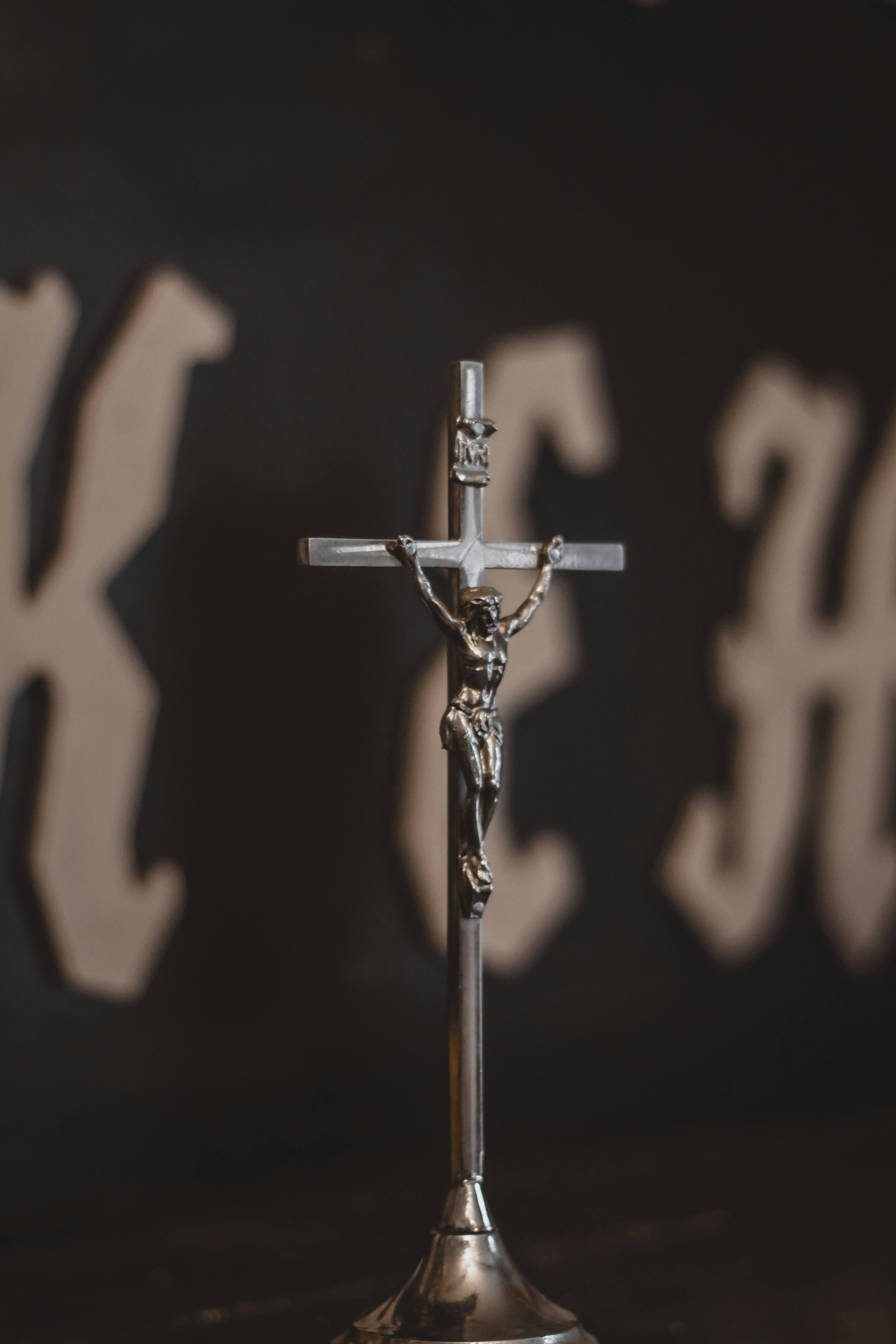 A crucifix on a table in front of a wall photo – Free Grey Image on ...