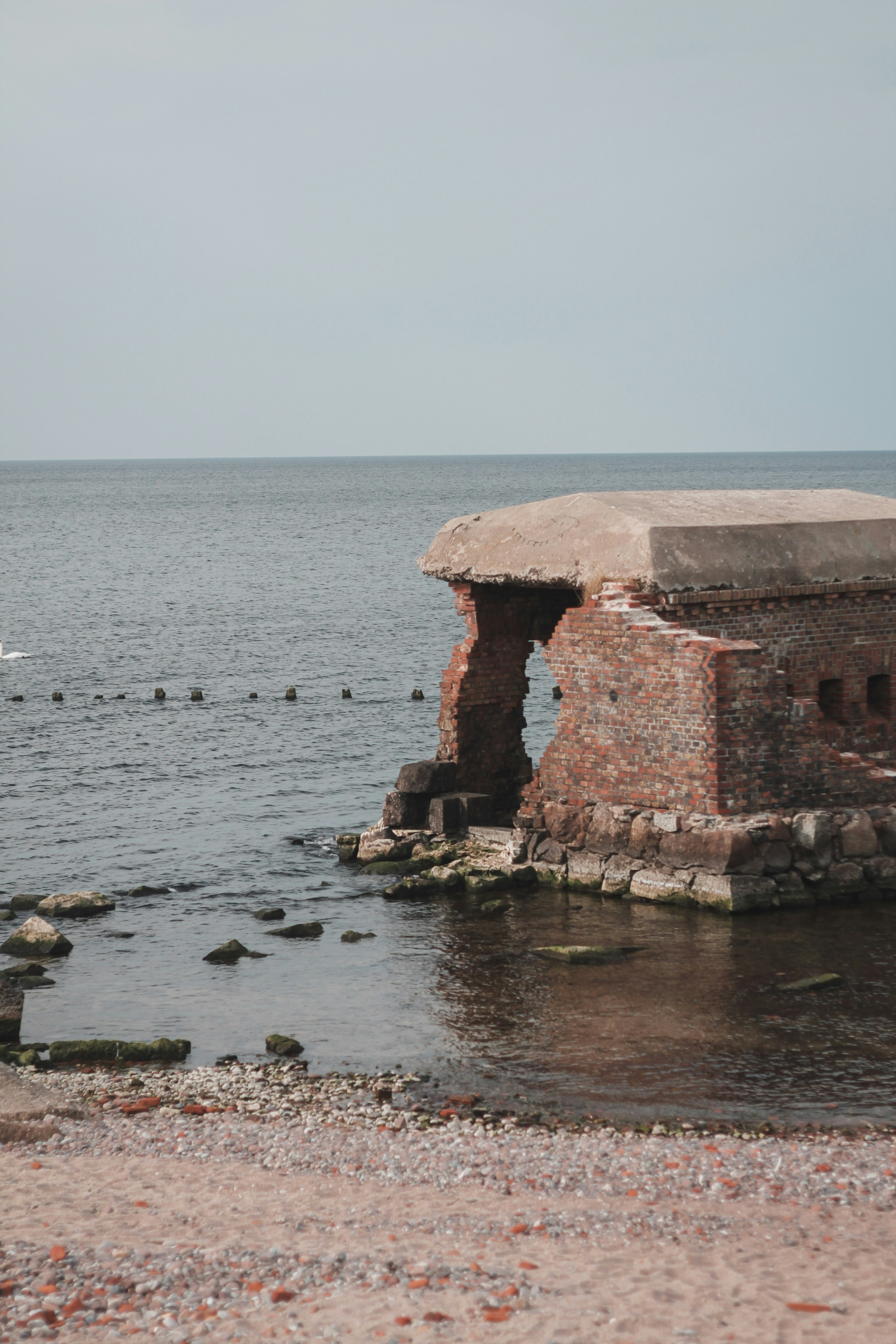 Brick Ruin at the Water's Edge: Weathered Sentinel Beside a Quiet Sea