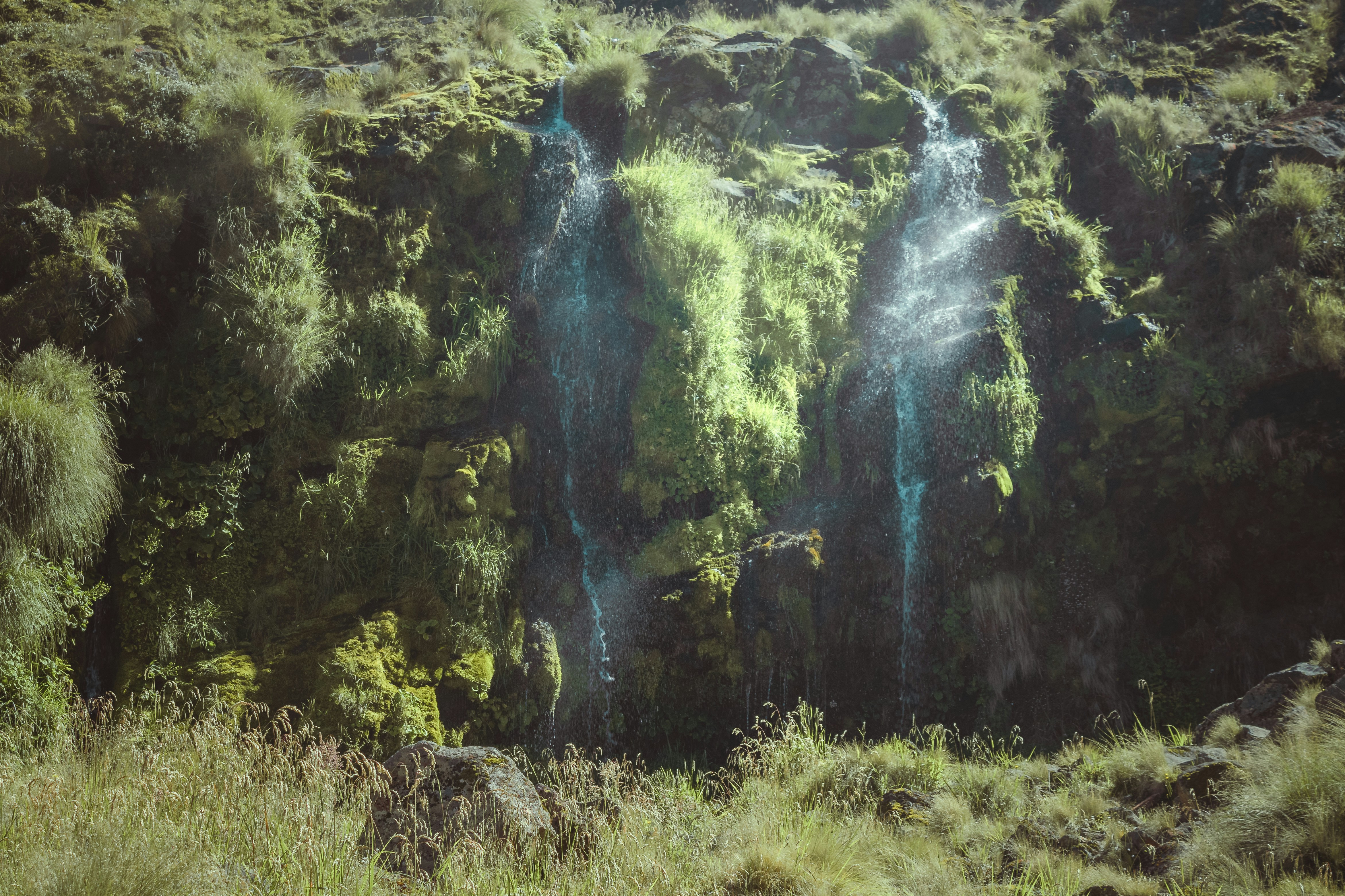 Une colline verdoyante avec une cascade au milieu photo – Photo La ...