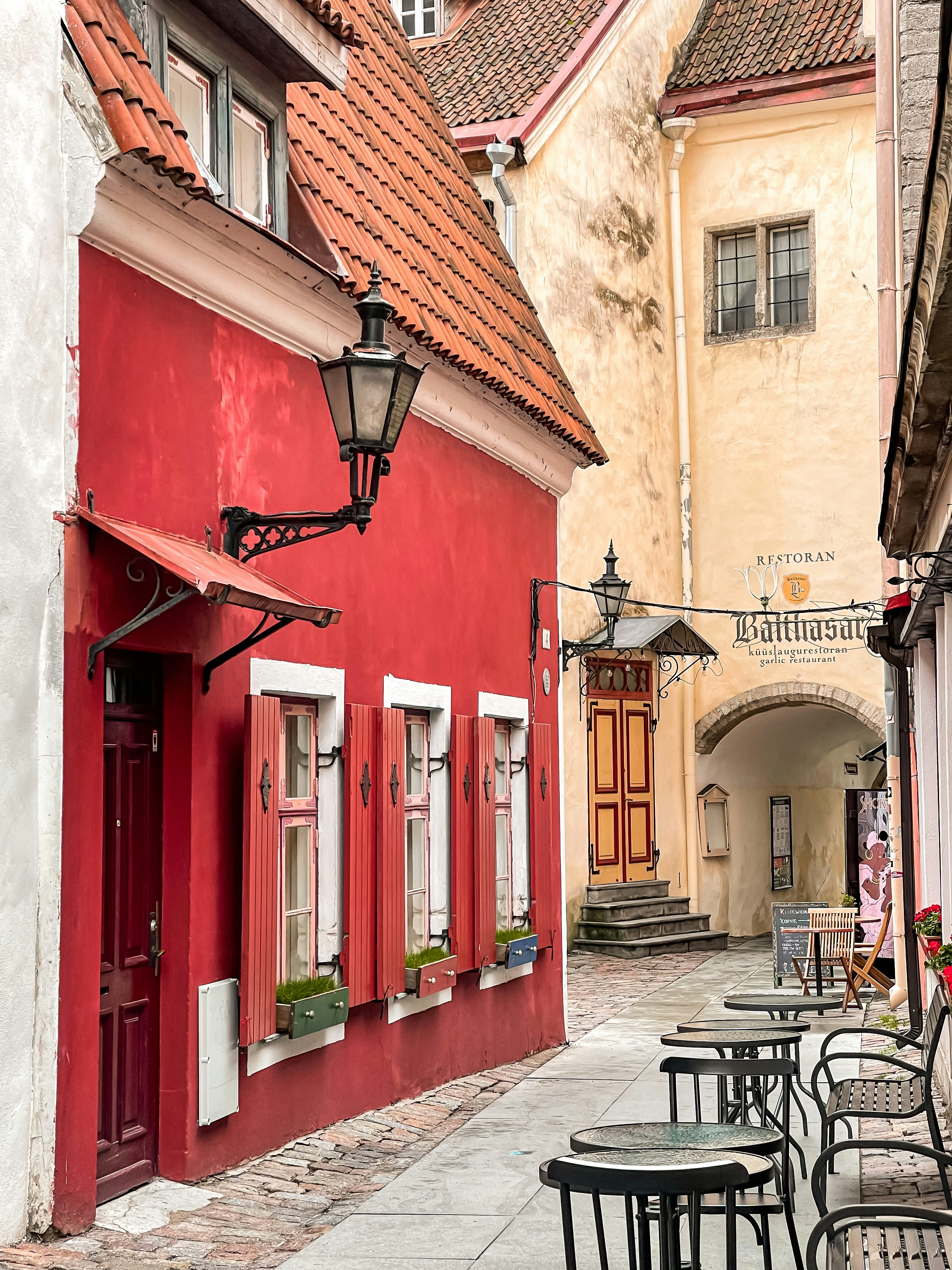 A row of tables and chairs in front of a red building photo – Free ...