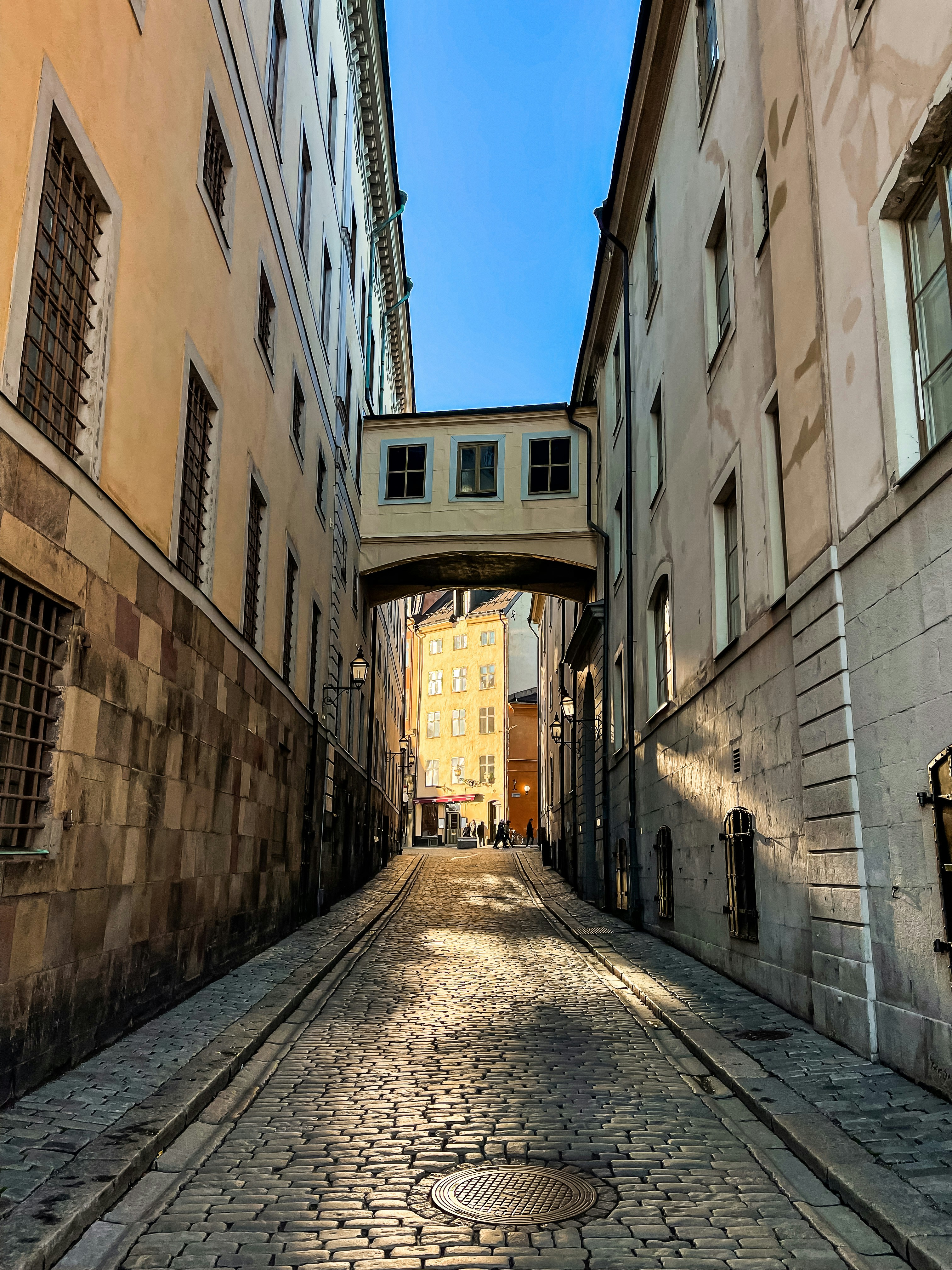 A cobblestone street with a bridge over it photo – Free Sweden Image on ...
