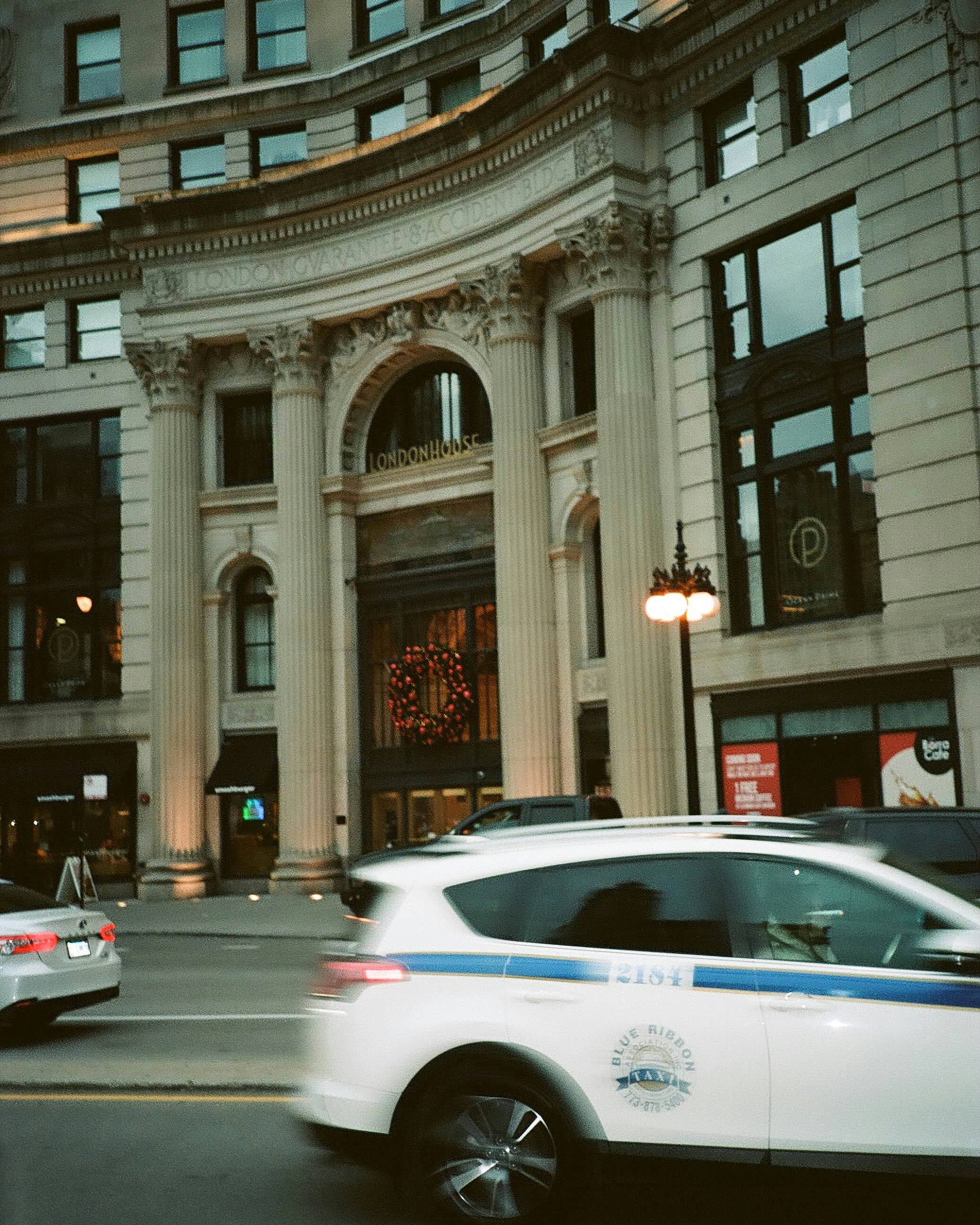 A white police car driving past a tall building photo – Free Chicago ...