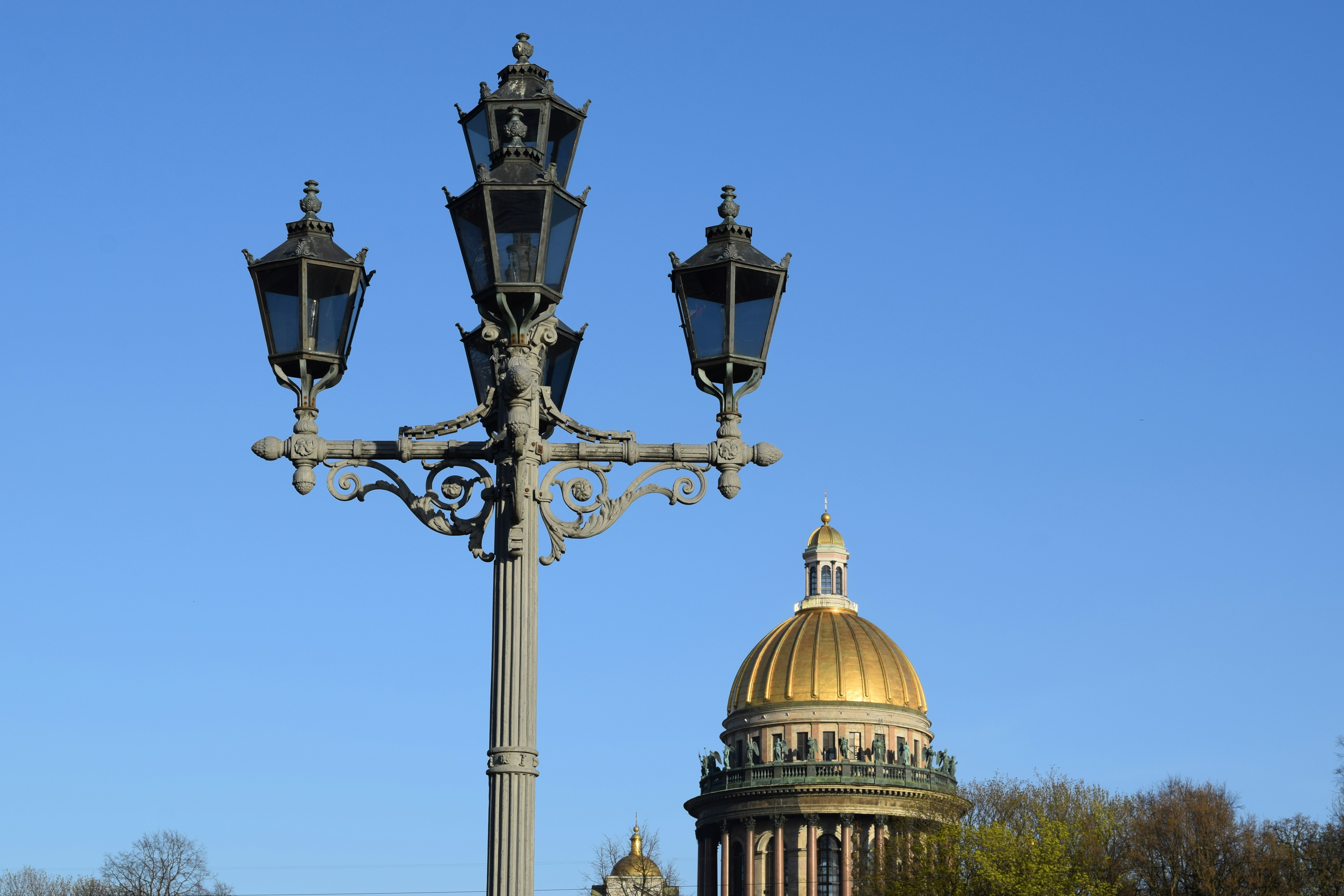 Ornate Lantern Framing a Golden Dome Against a Clear Blue Sky