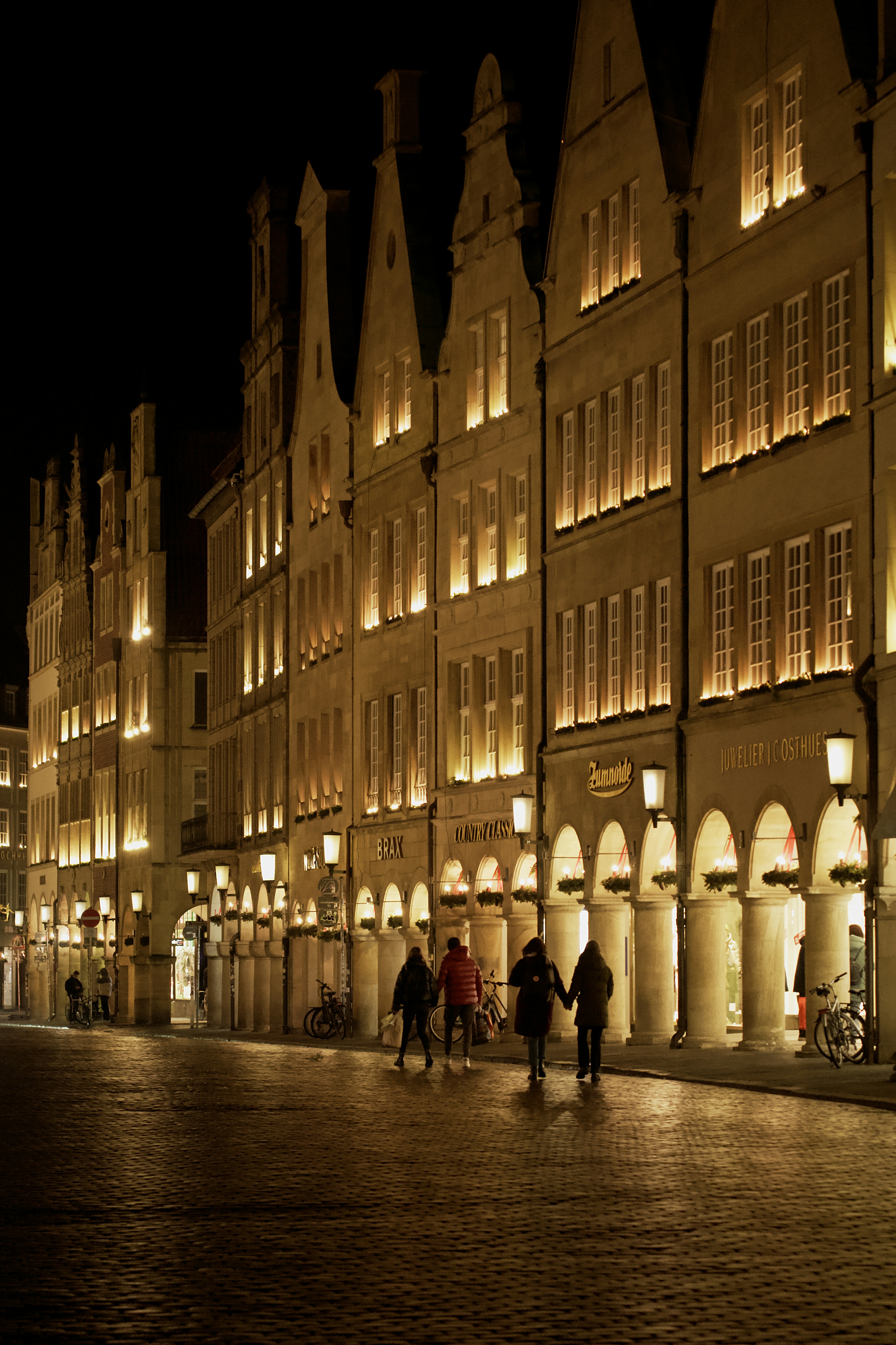 Foto zum Thema Eine Gruppe von Menschen, die eine Straße neben hohen ...