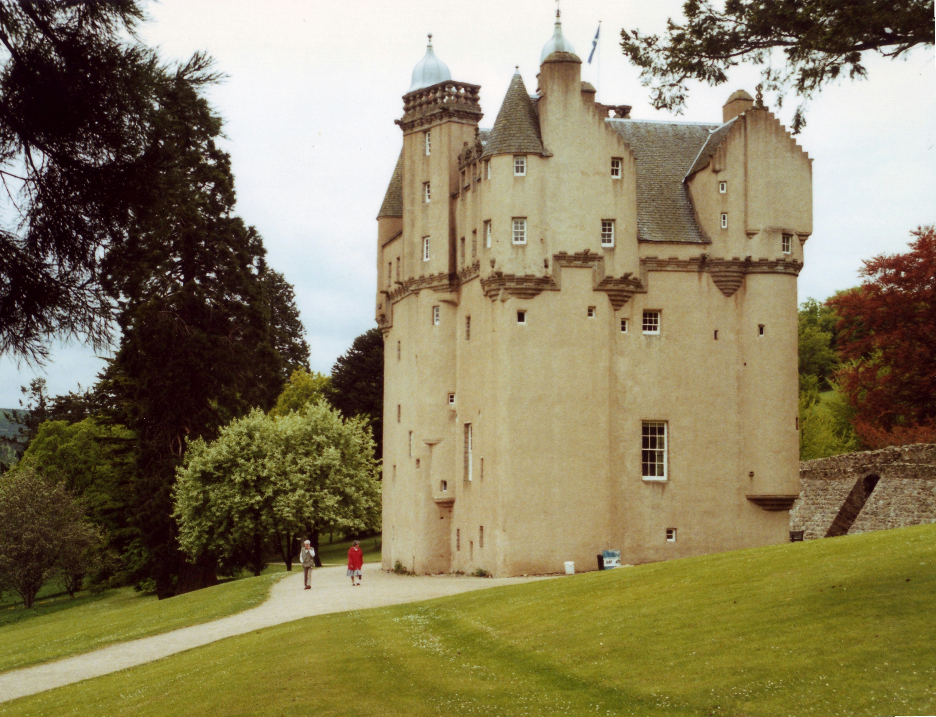 A large castle like building sitting on top of a lush green field photo ...
