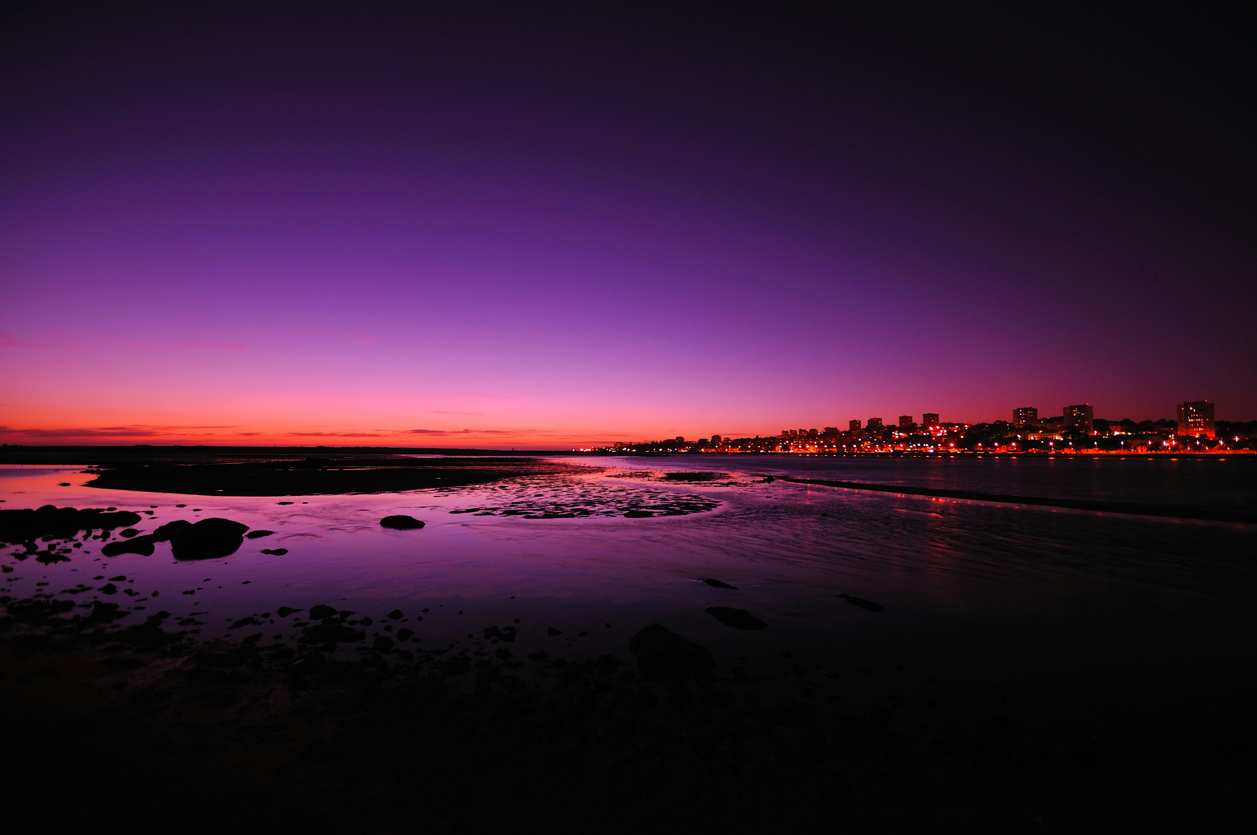 Horizon Glow Over Velvet Tide: City Lights at Dusk