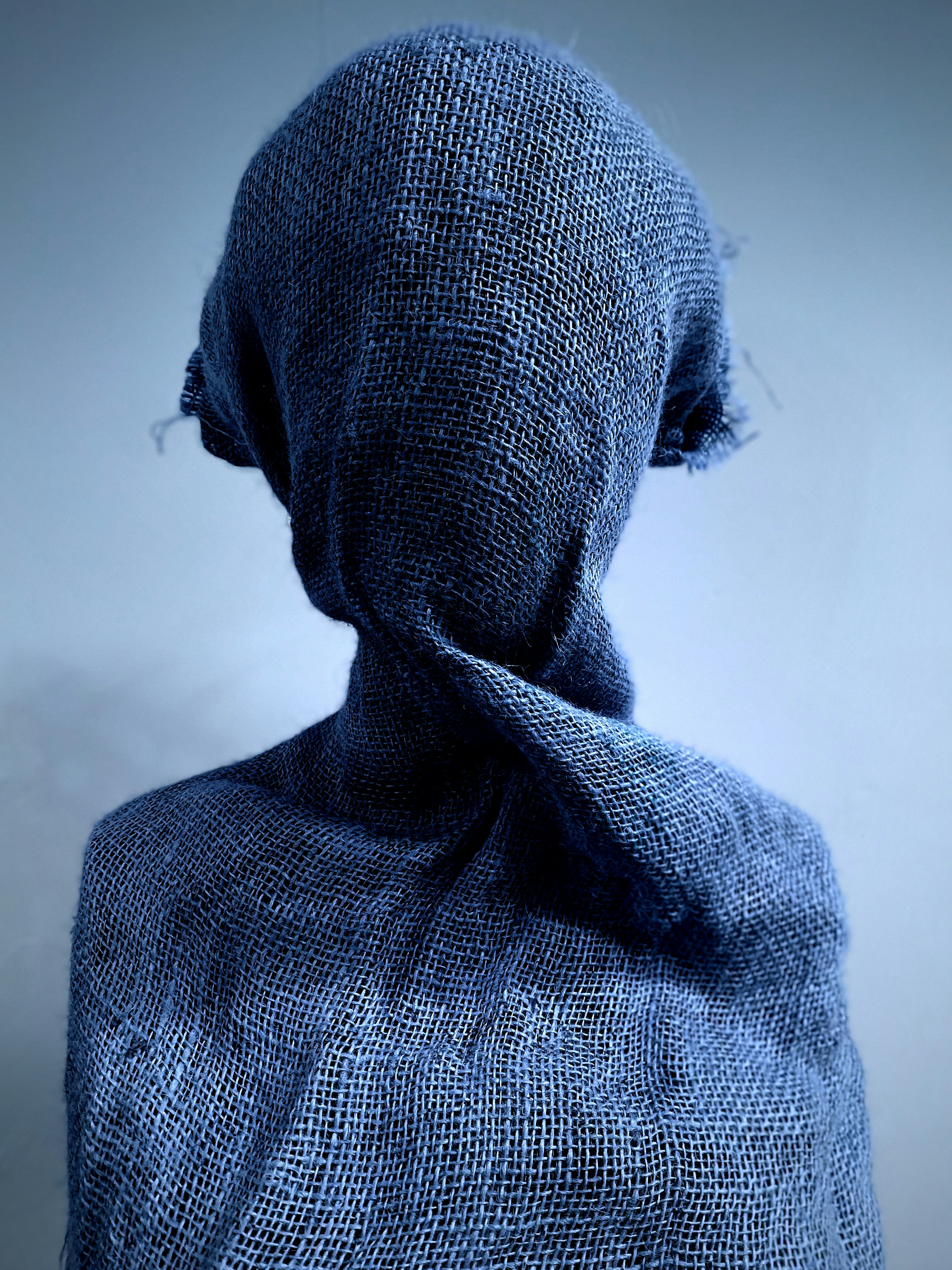 Blue Burlap Vigil: A Portrait Shrouded in Fabric