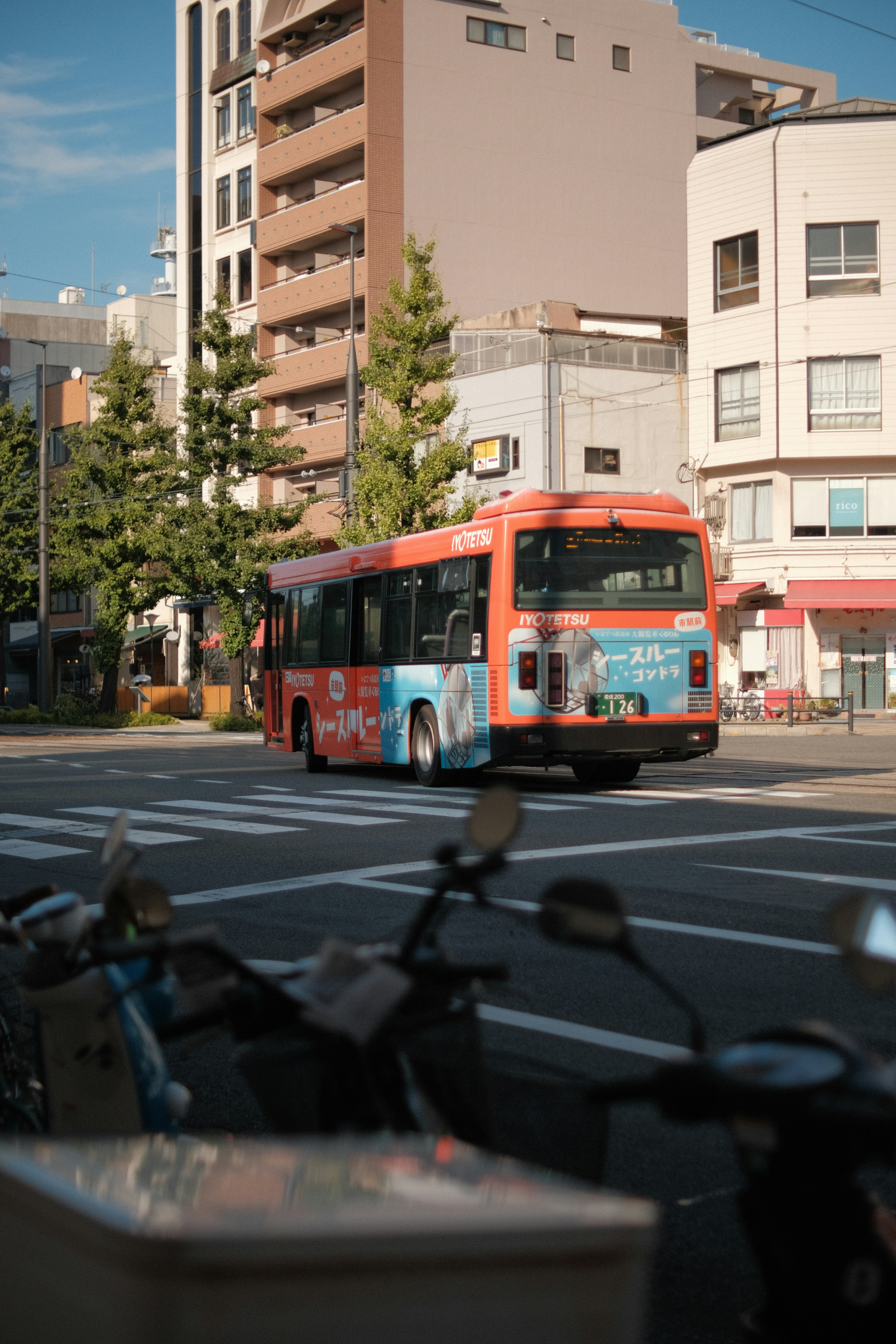 Un autobús urbano conduciendo por una calle junto a edificios altos ...