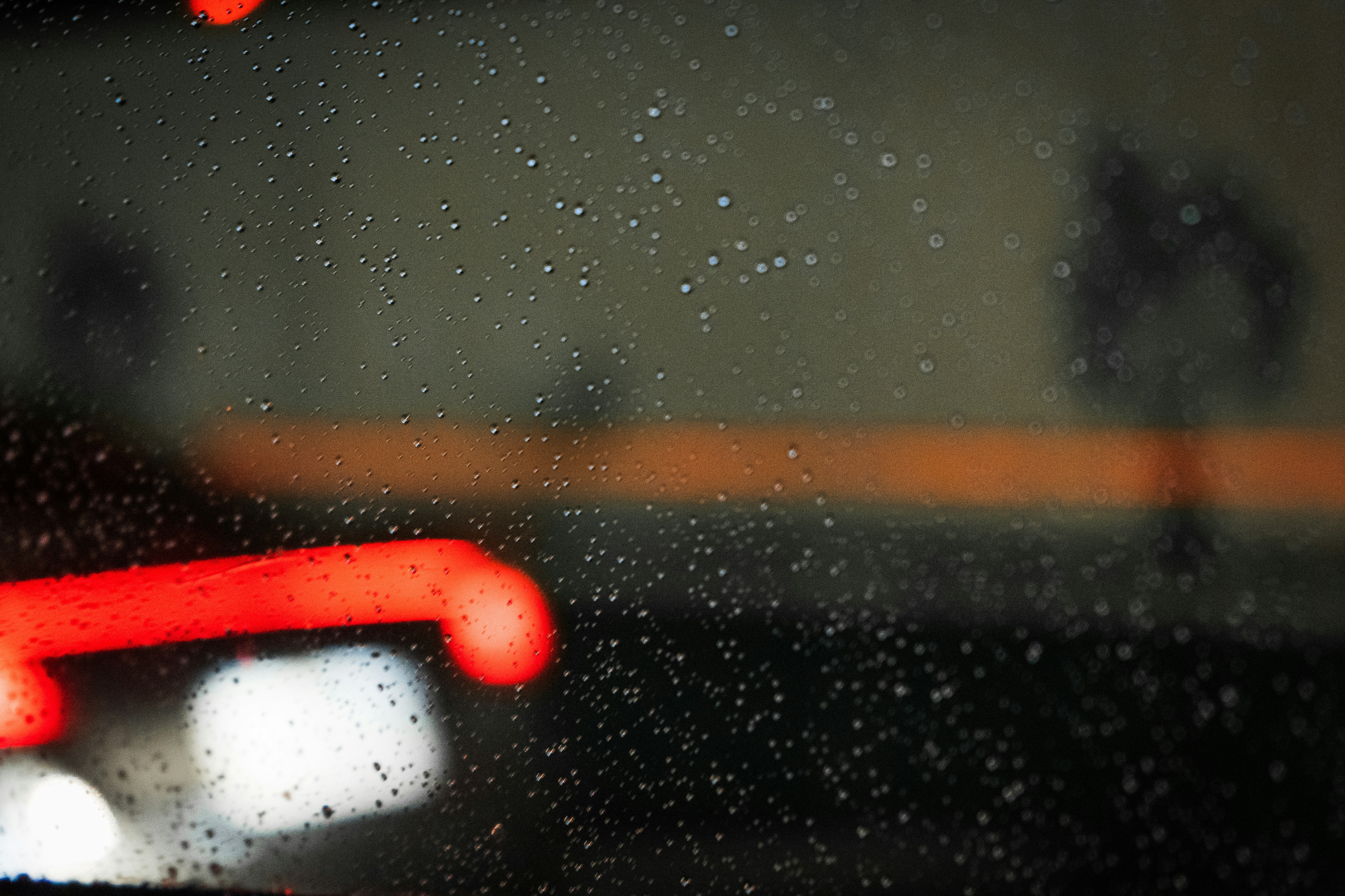 Red Taillight Arc Through Rain on a Night Drive