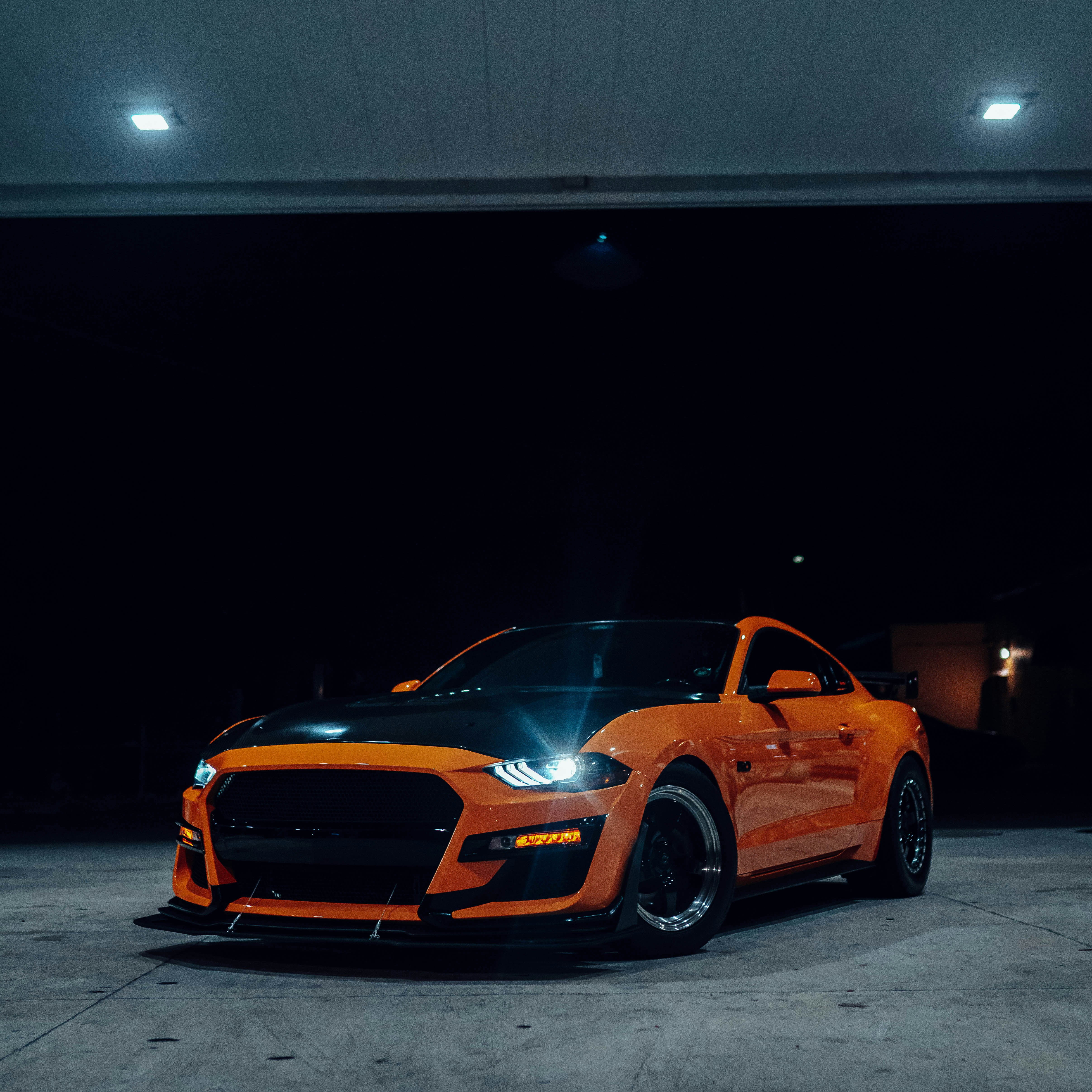 Midnight Thunder: Orange Mustang Rumbles Under Neon Sky