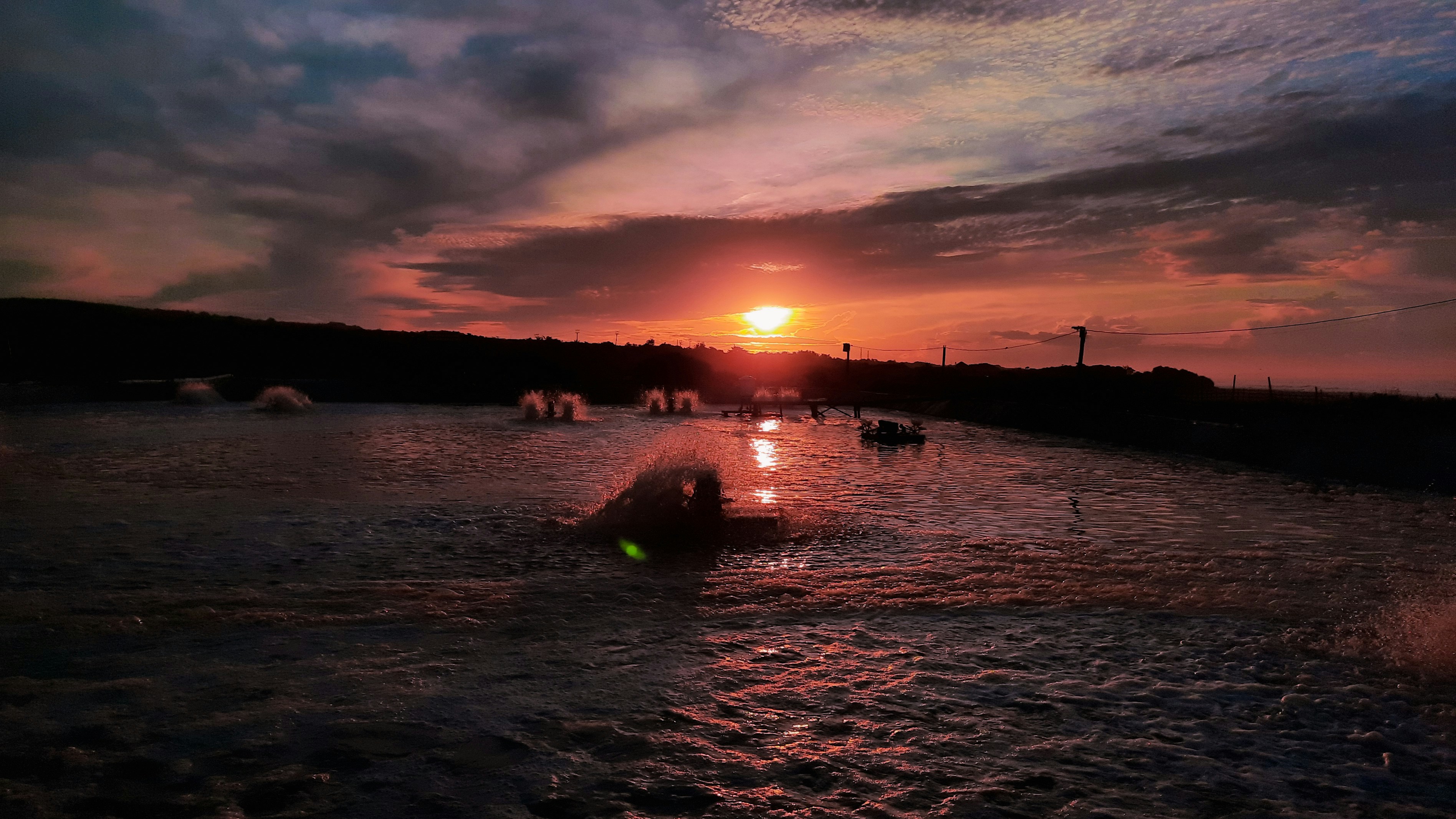 Ember Horizon over a Quiet Channel: Silhouetted Boats at Dusk