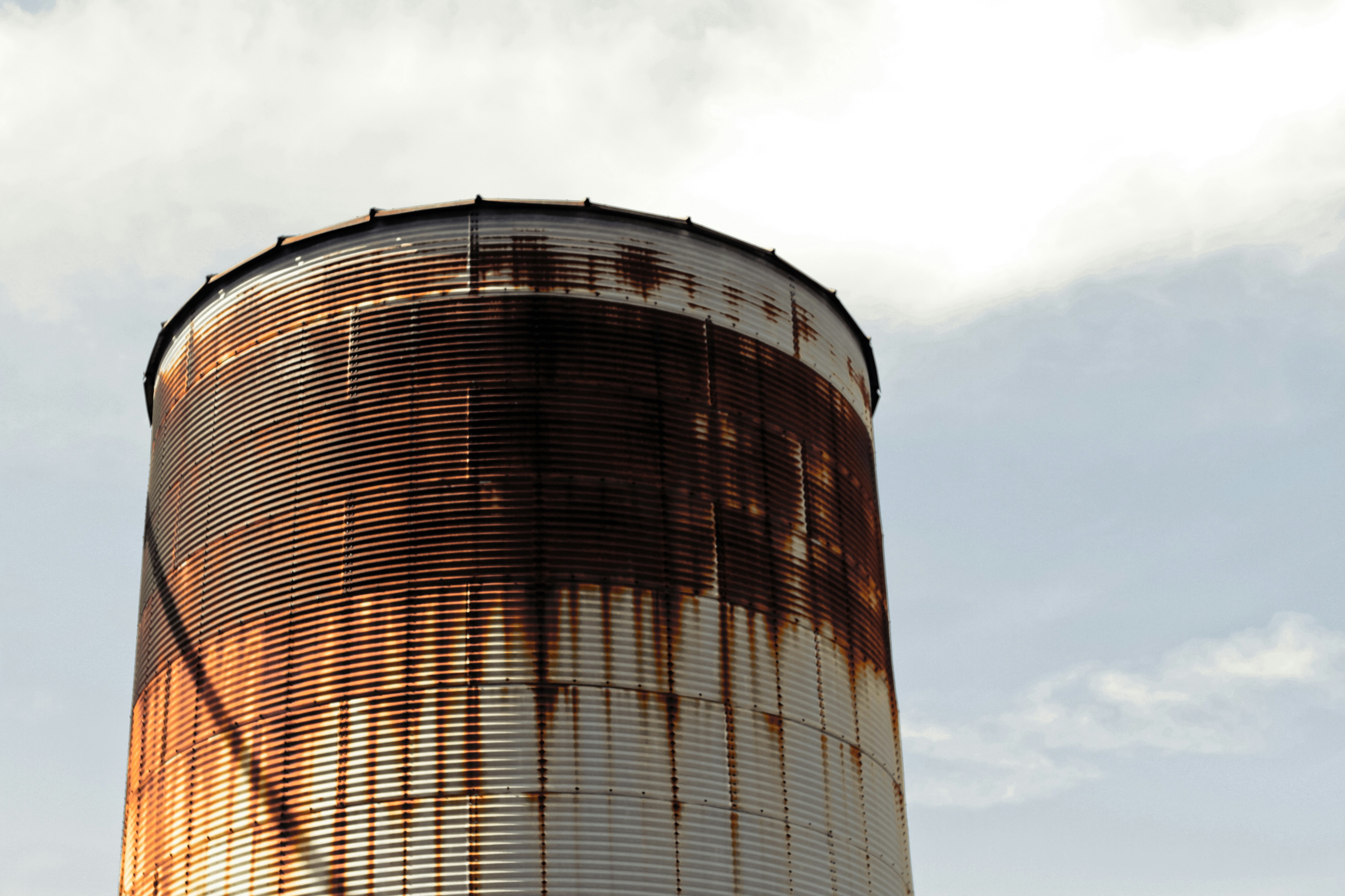 A rusted metal silo against a blue sky photo – Free Indiana Image on ...
