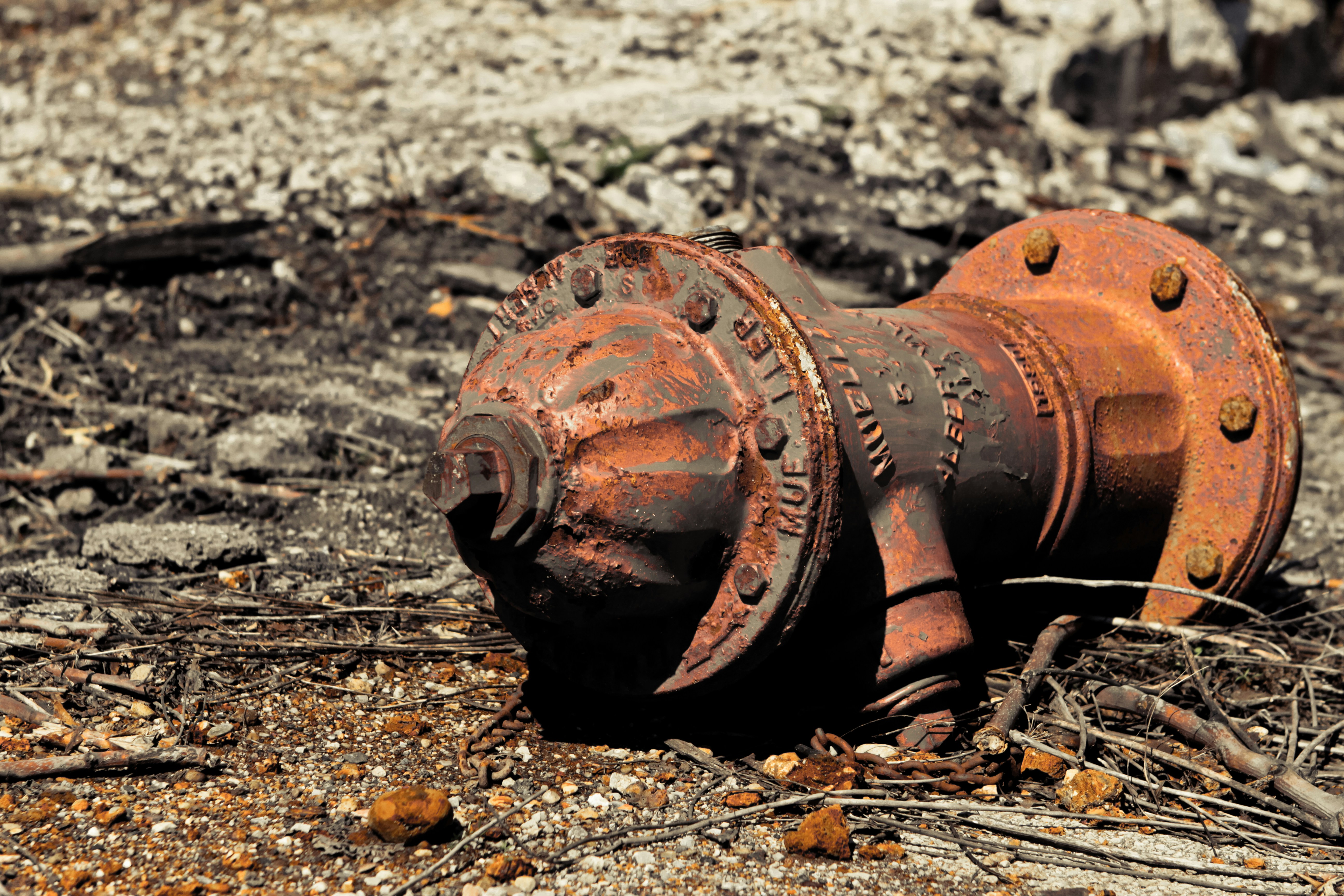 an old rusted fire hydrant laying on the ground