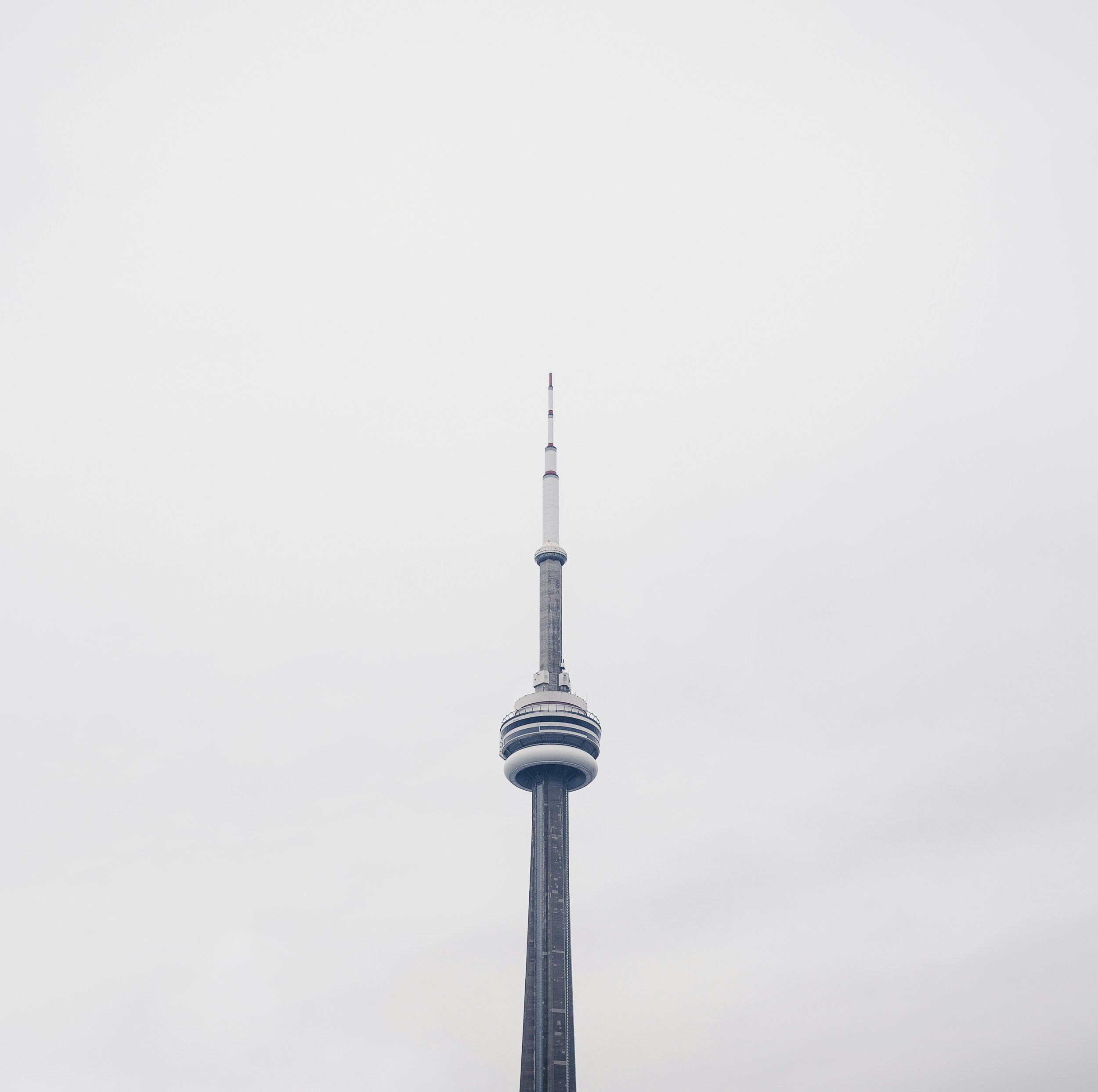 Tall communications tower against a cloudy sky.