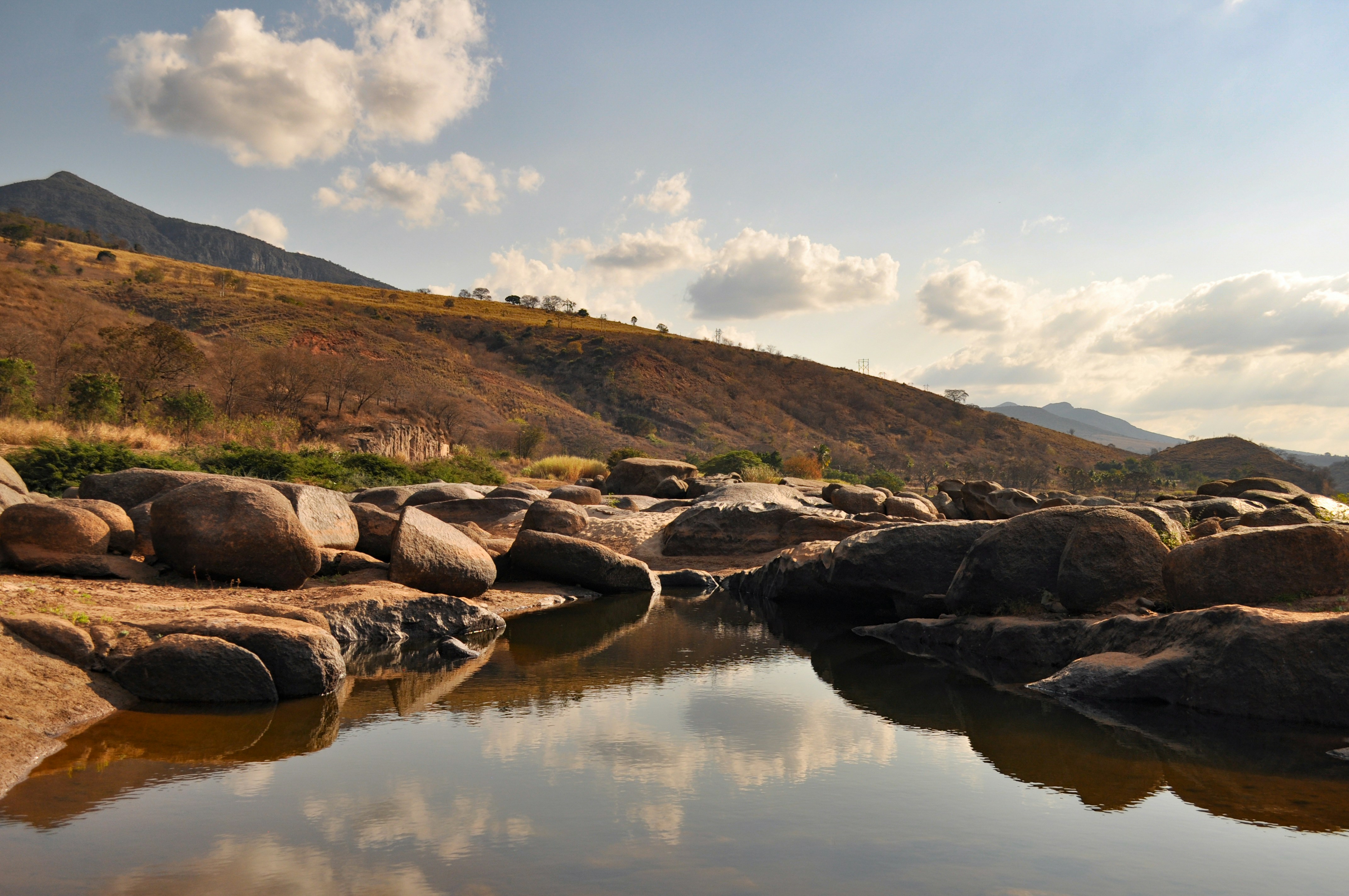 A stream of water surrounded by large rocks photo – Free Shoreline ...