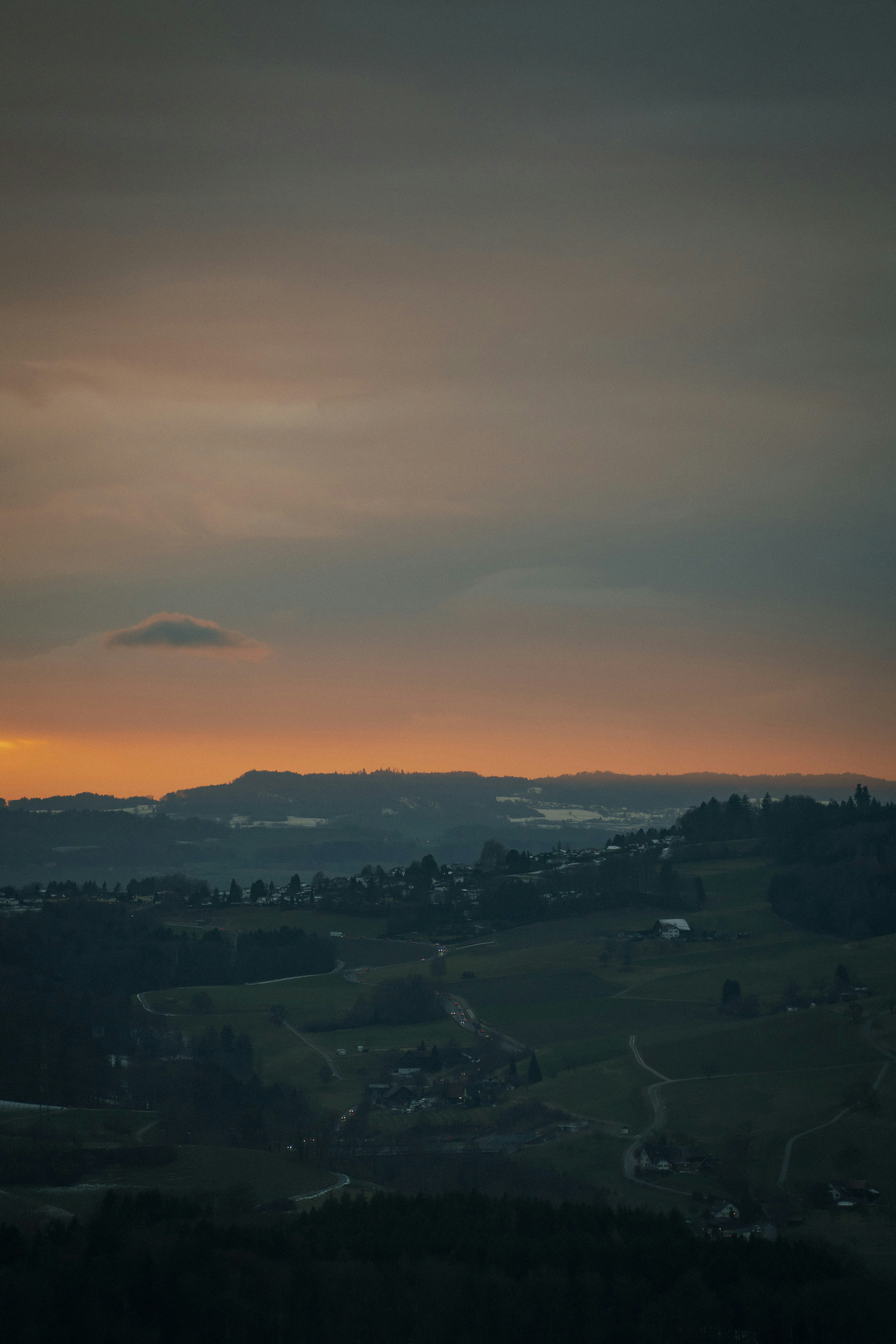 The sun is setting over a valley with hills in the distance photo ...