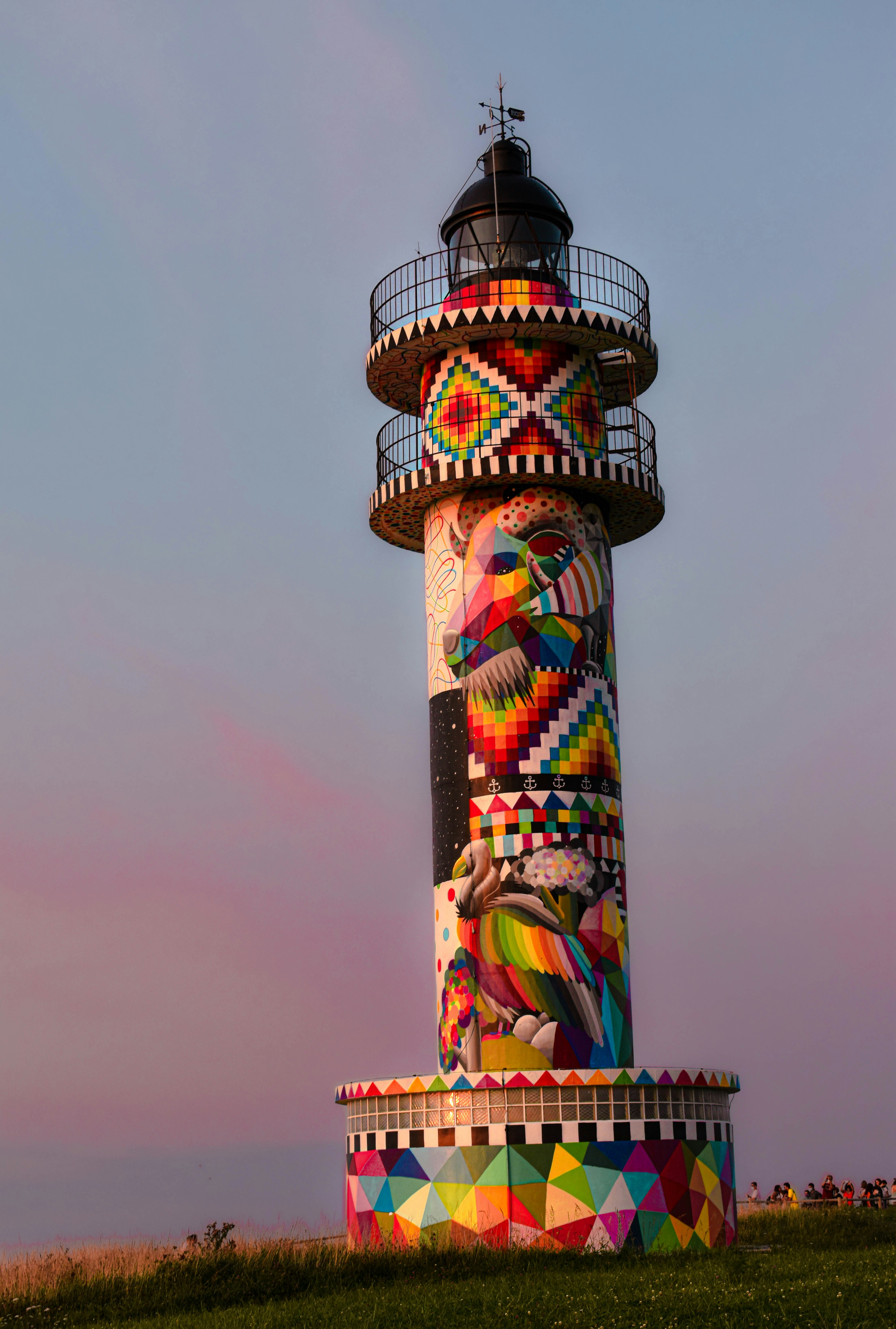 A large multicolored lighthouse on top of a hill photo – Free Cantabria ...