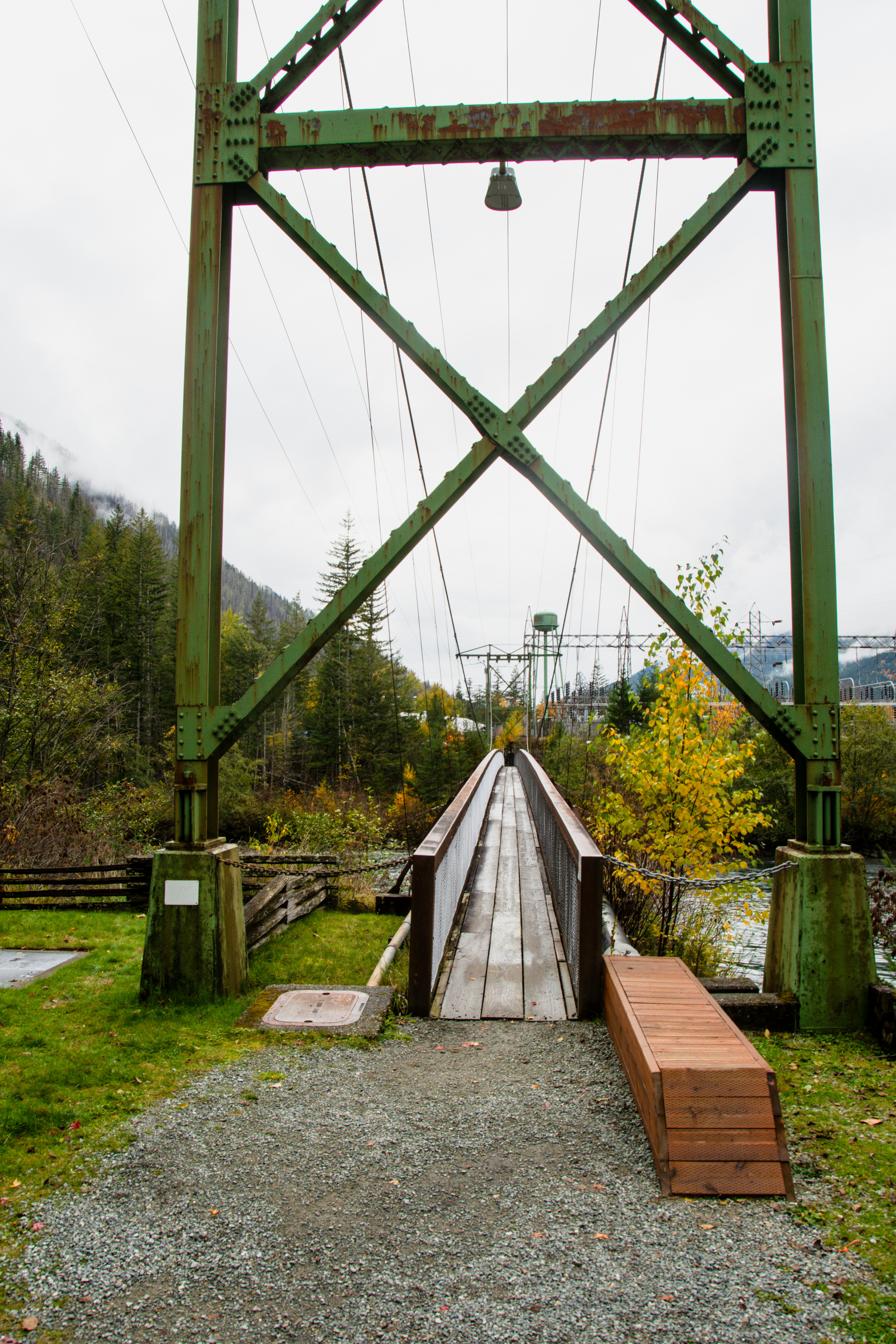 Emerald Truss Bridge: Narrow Wooden Crossing Through Autumn Valley