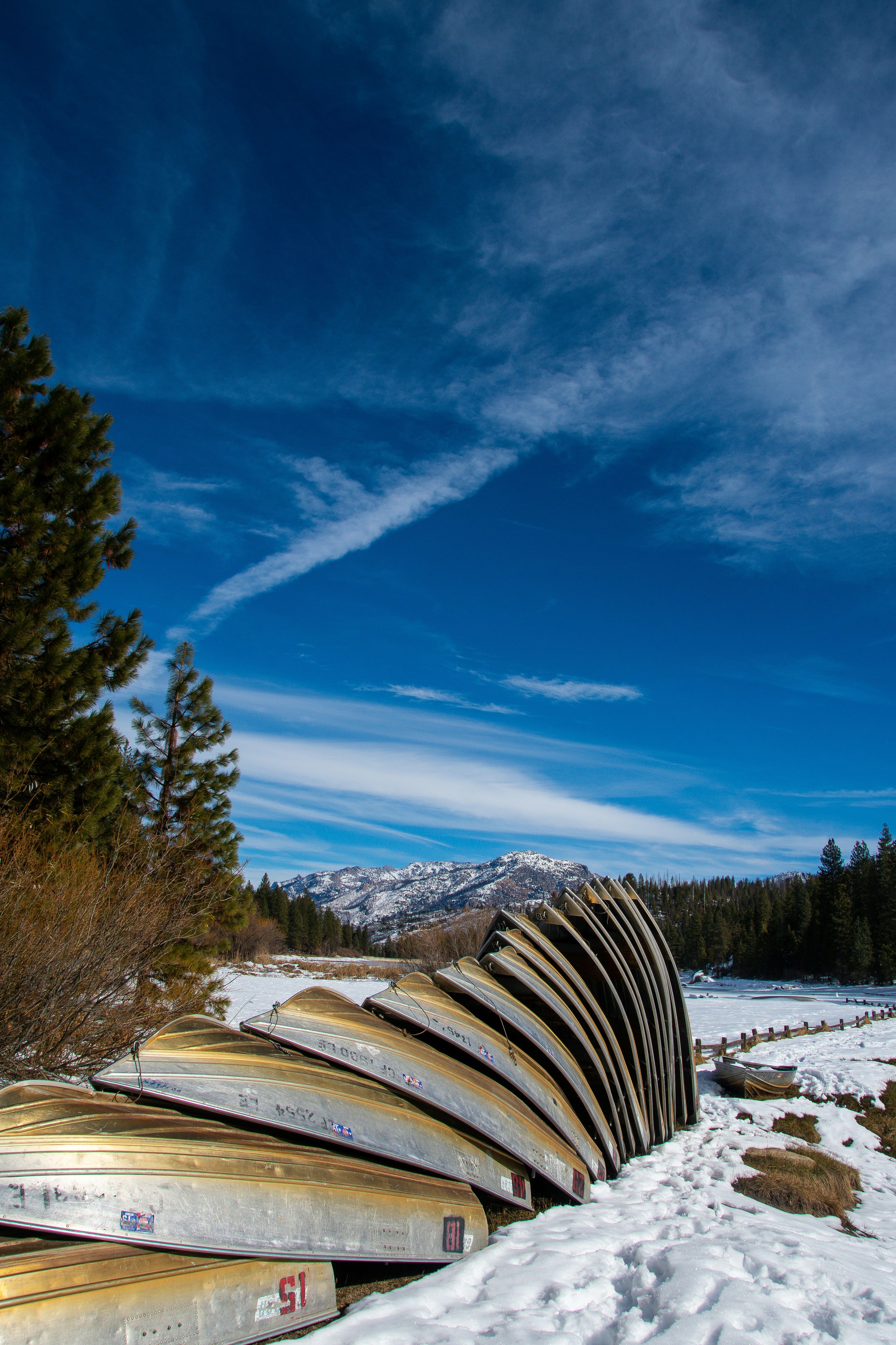 A row of canoes sitting on top of snow covered ground photo – Free Blue ...