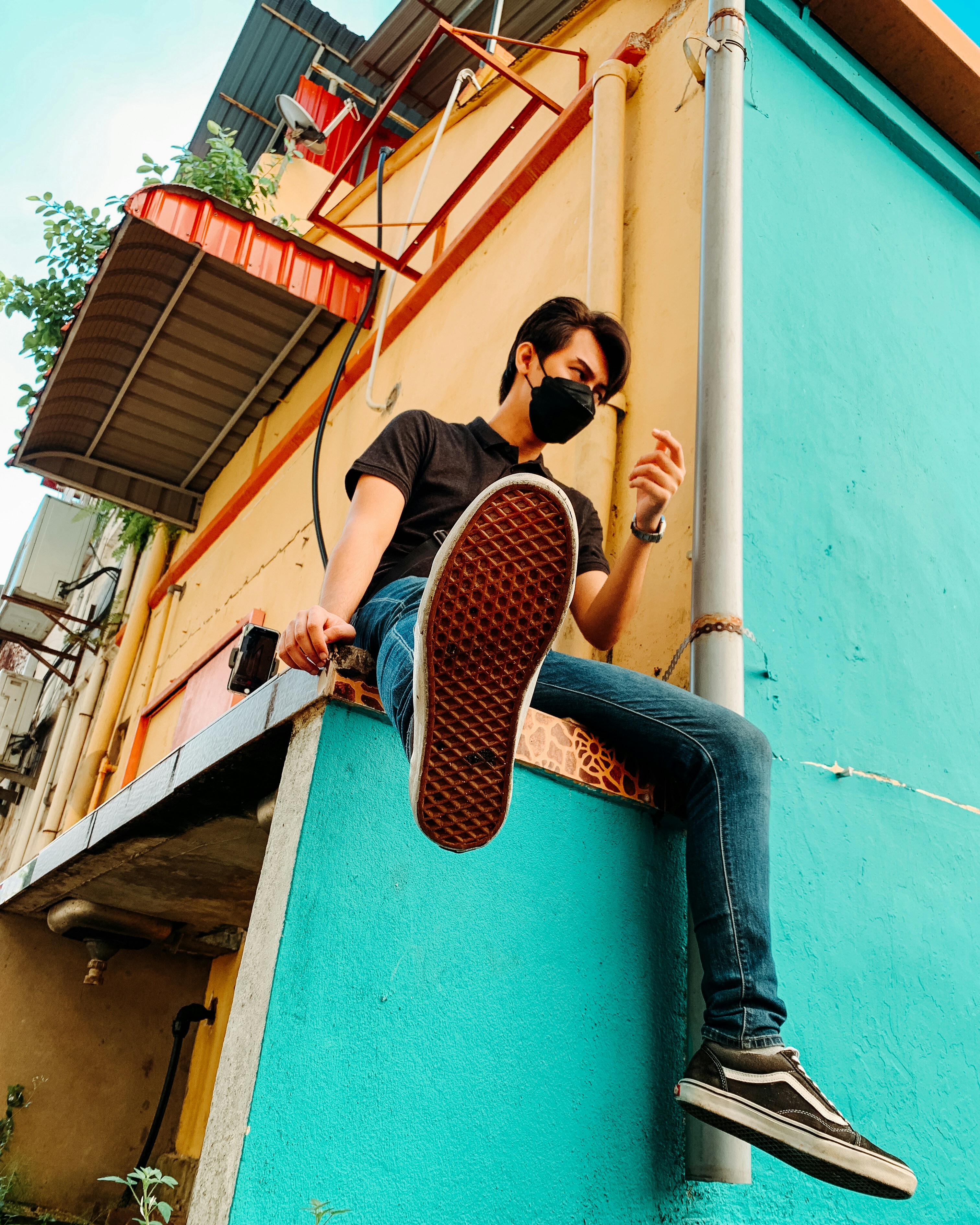 Sneaker Over the Edge: A Quiet Rebellion on a Teal Wall