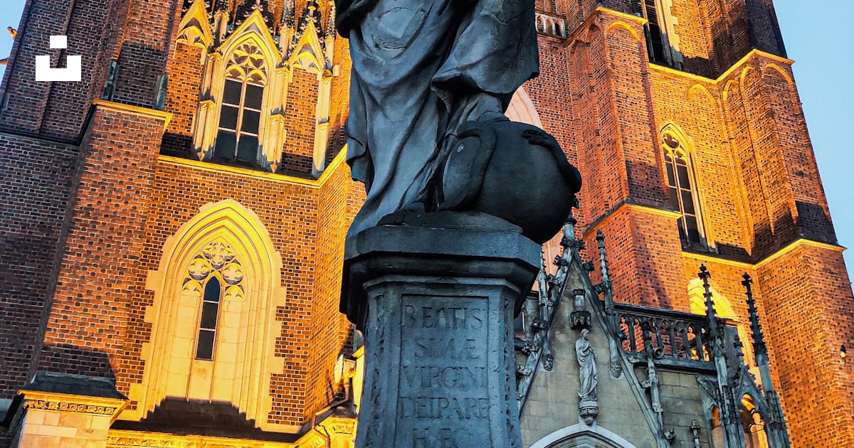 Un Edificio Alto Con Una Estatua Frente A él Foto Imagen De
