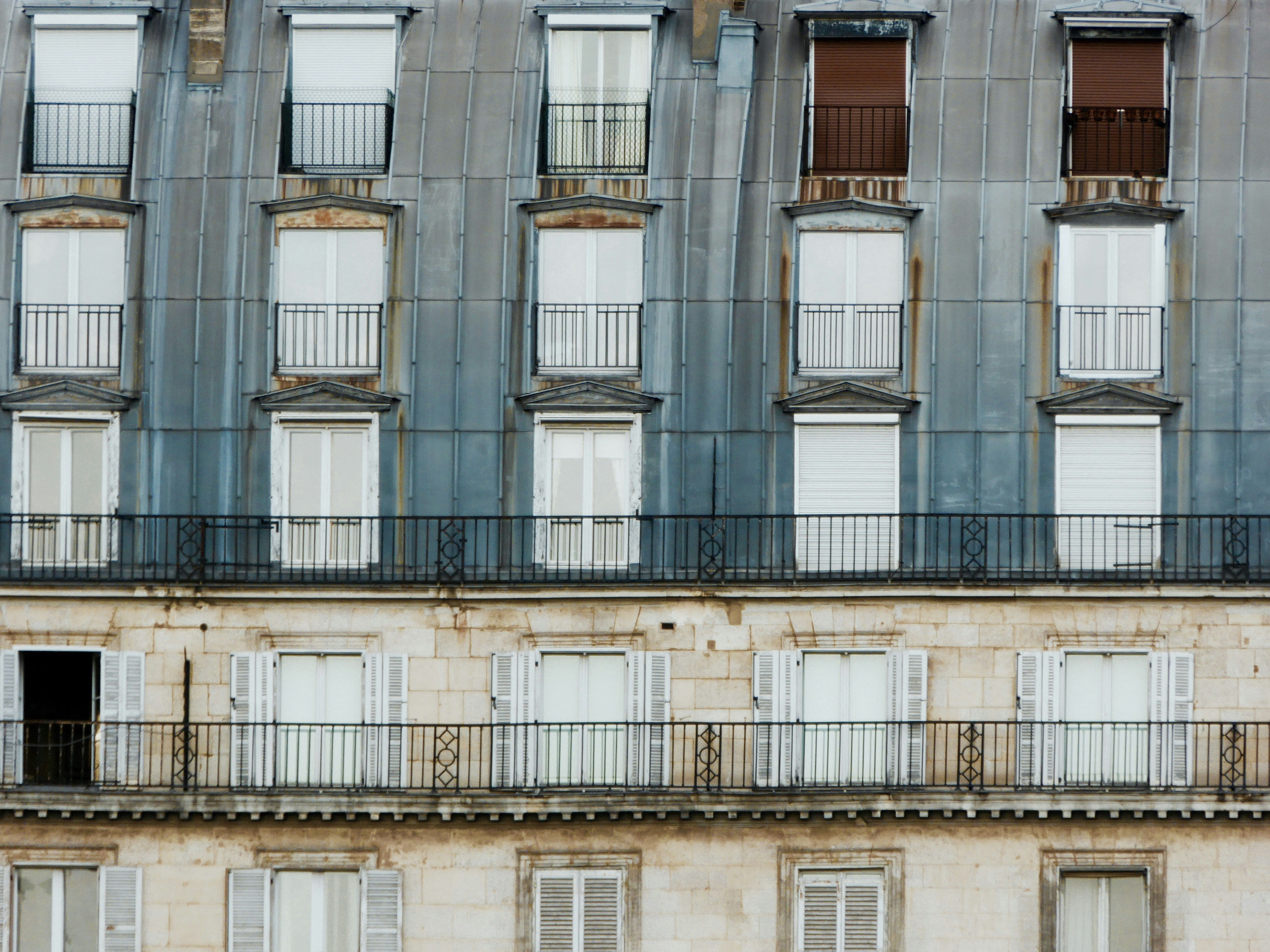 Historic building facade showcasing elegant balconies and a mix of window styles, reflecting urban architecture's charm.