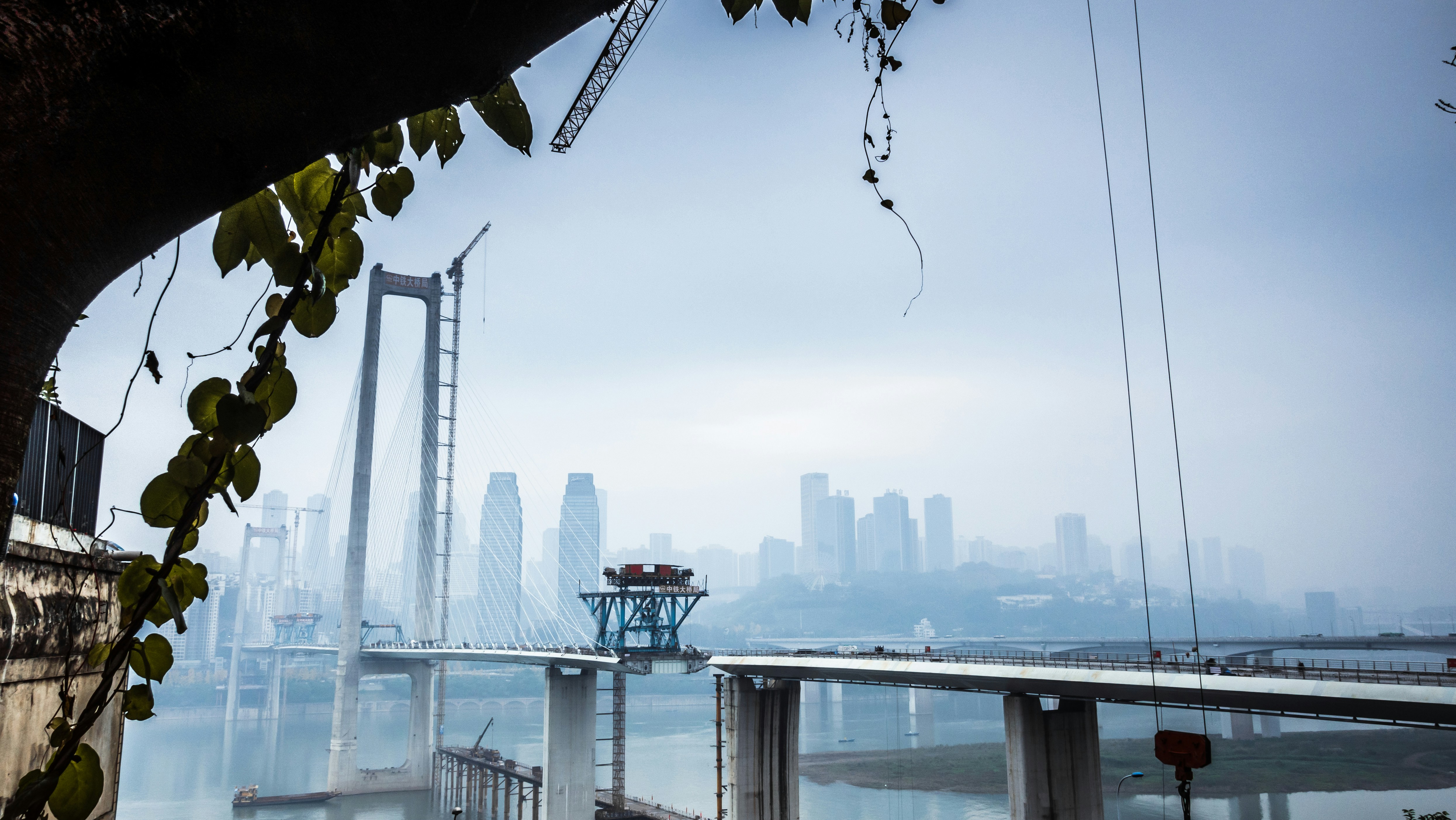 a bridge over a body of water with a city in the background