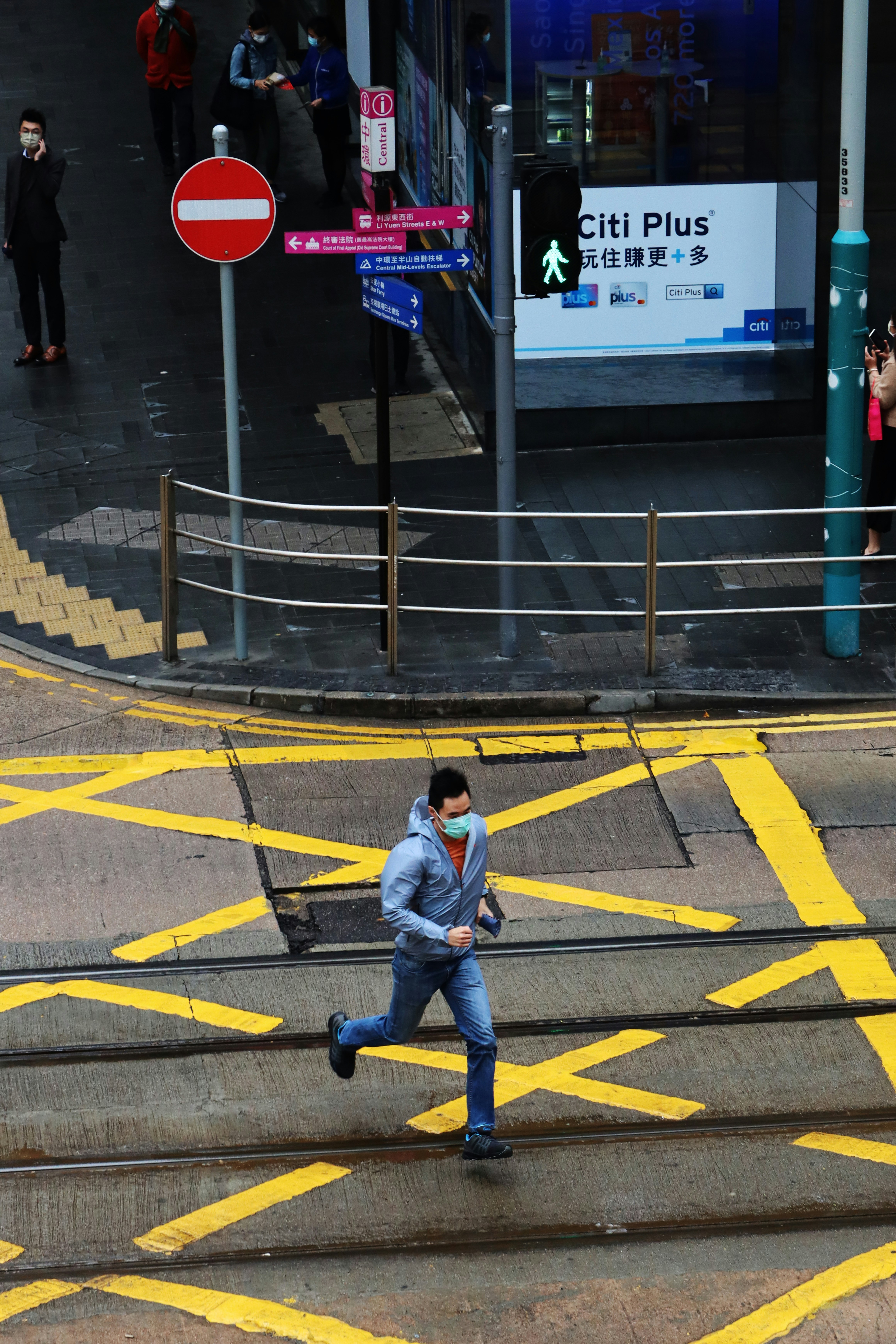 A man wearing a face mask crossing a street photo – Free 香港 Image on ...