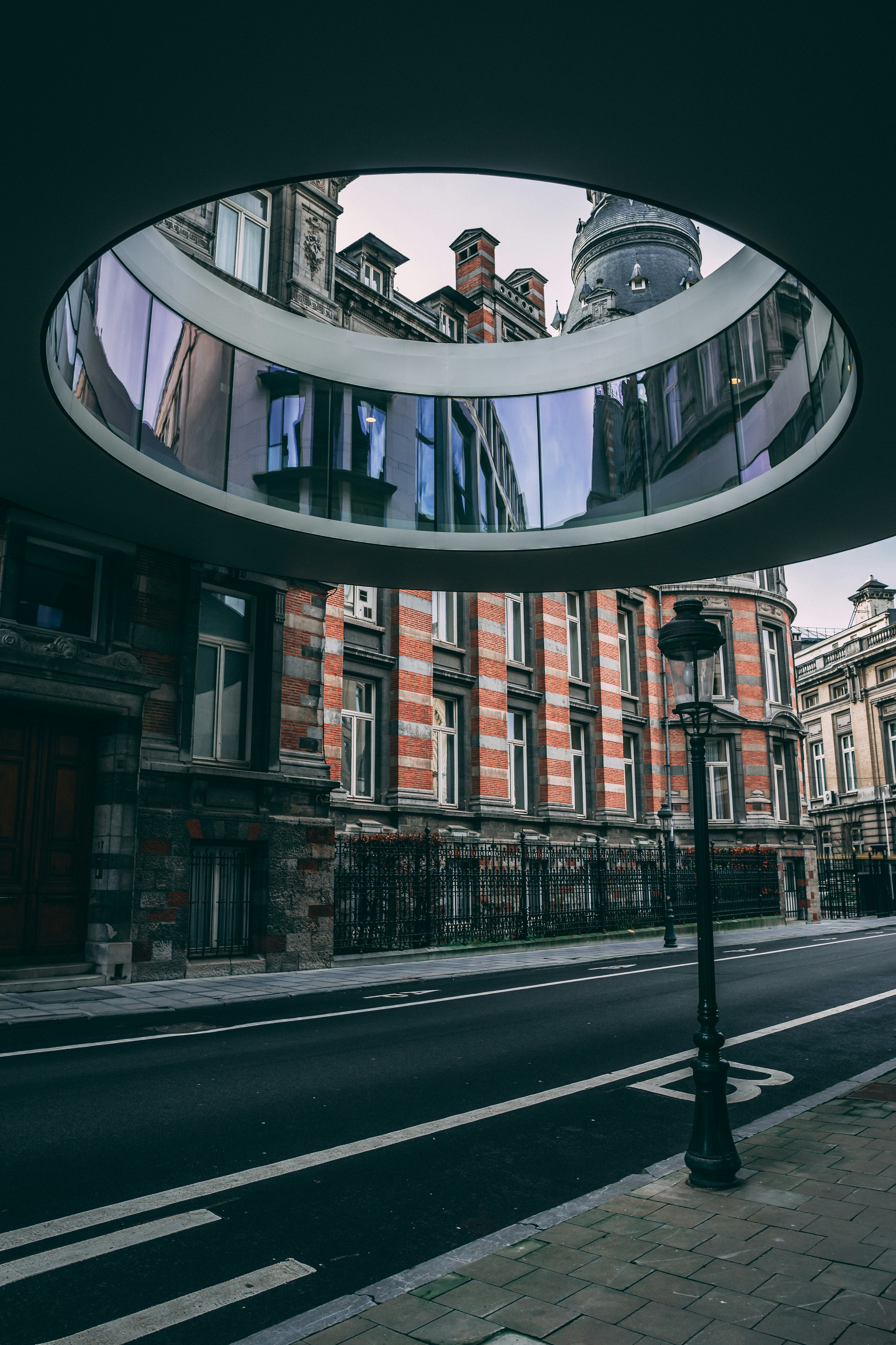 Halo Over the Street: Circular Skylight Reflects a Red-Brick Facade