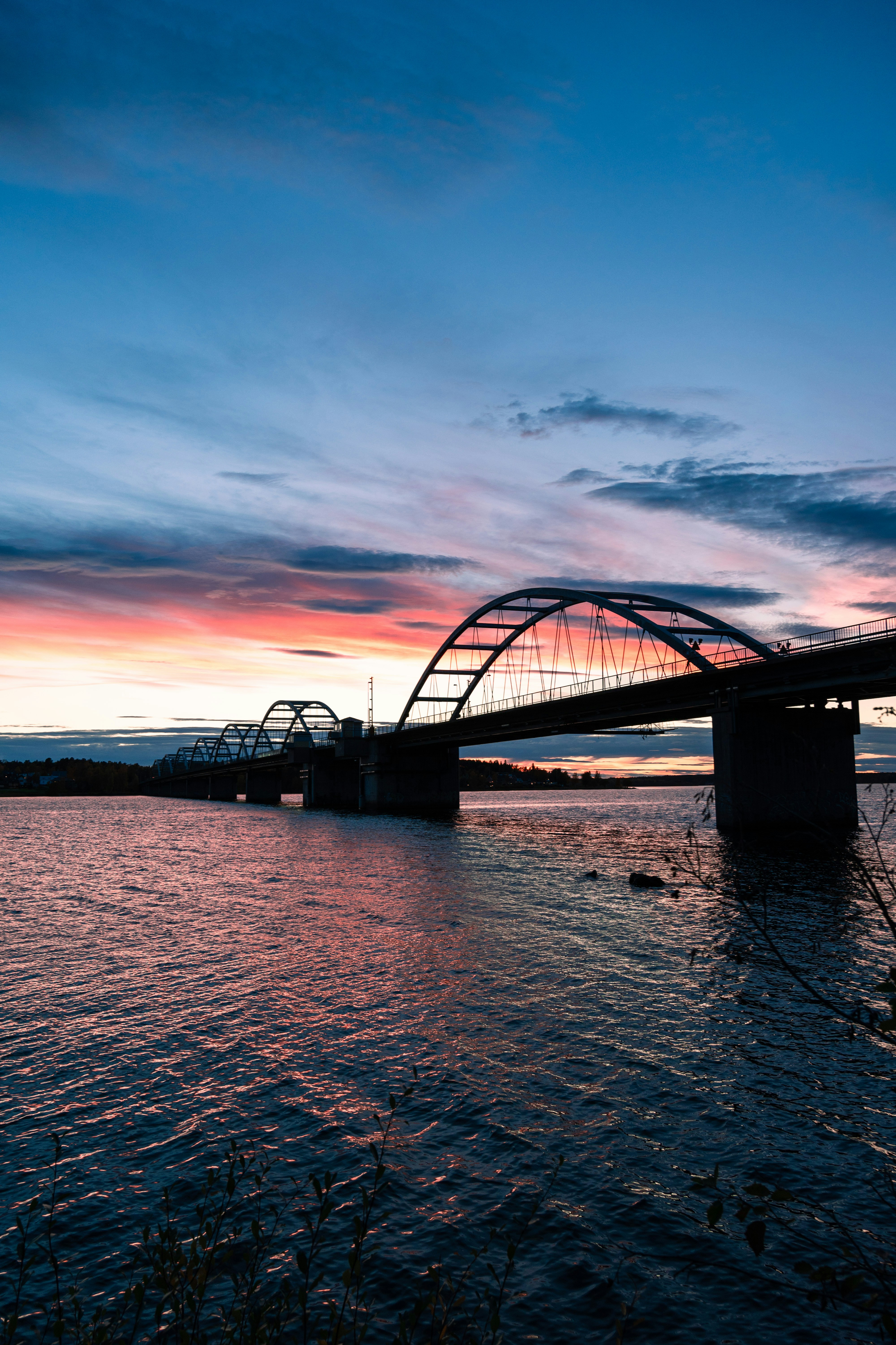 Sunset Over a Silhouetted Arch: A Quiet River Bridge