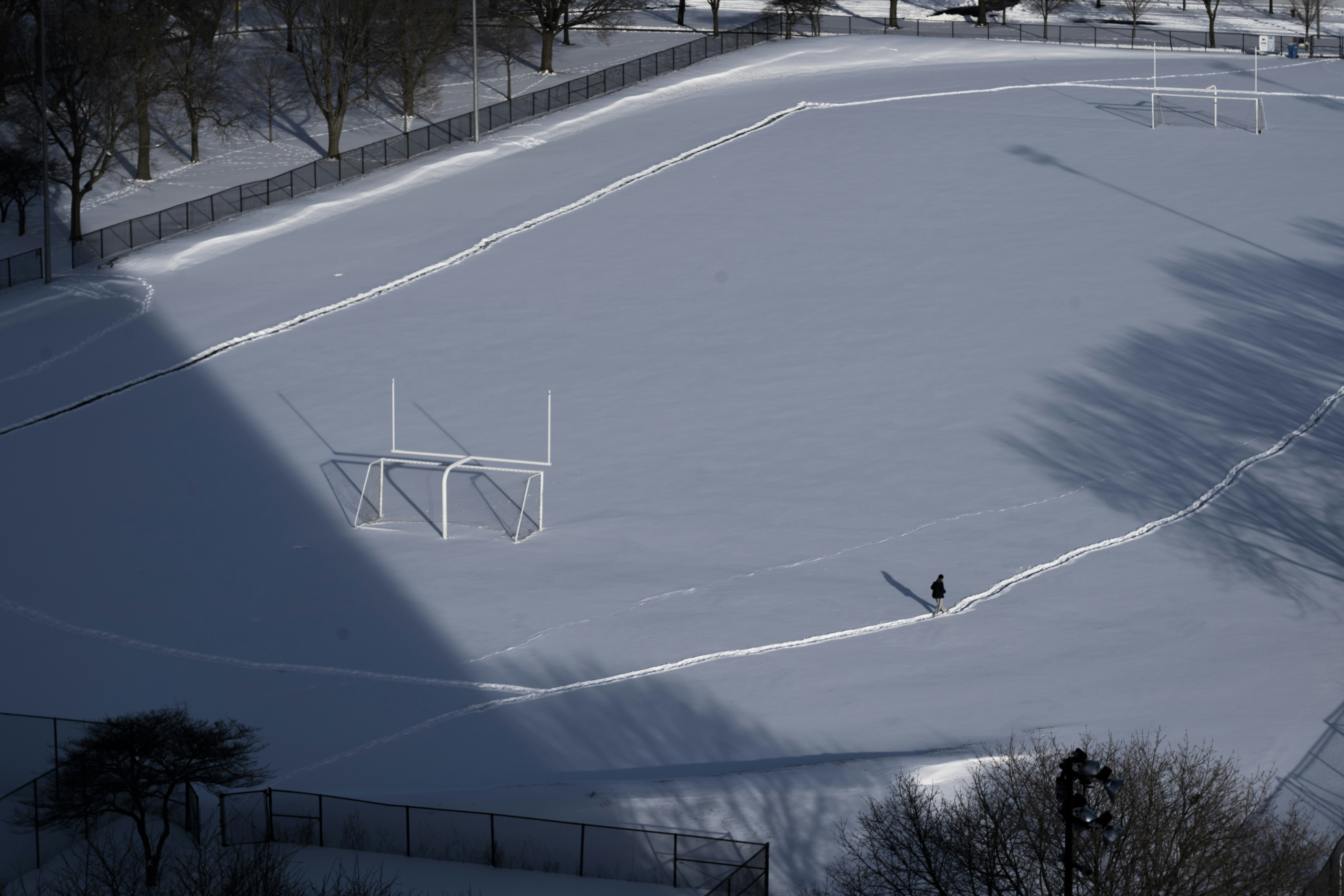 Lone Figure Tracing Quiet Lines Across a Snowbound Field