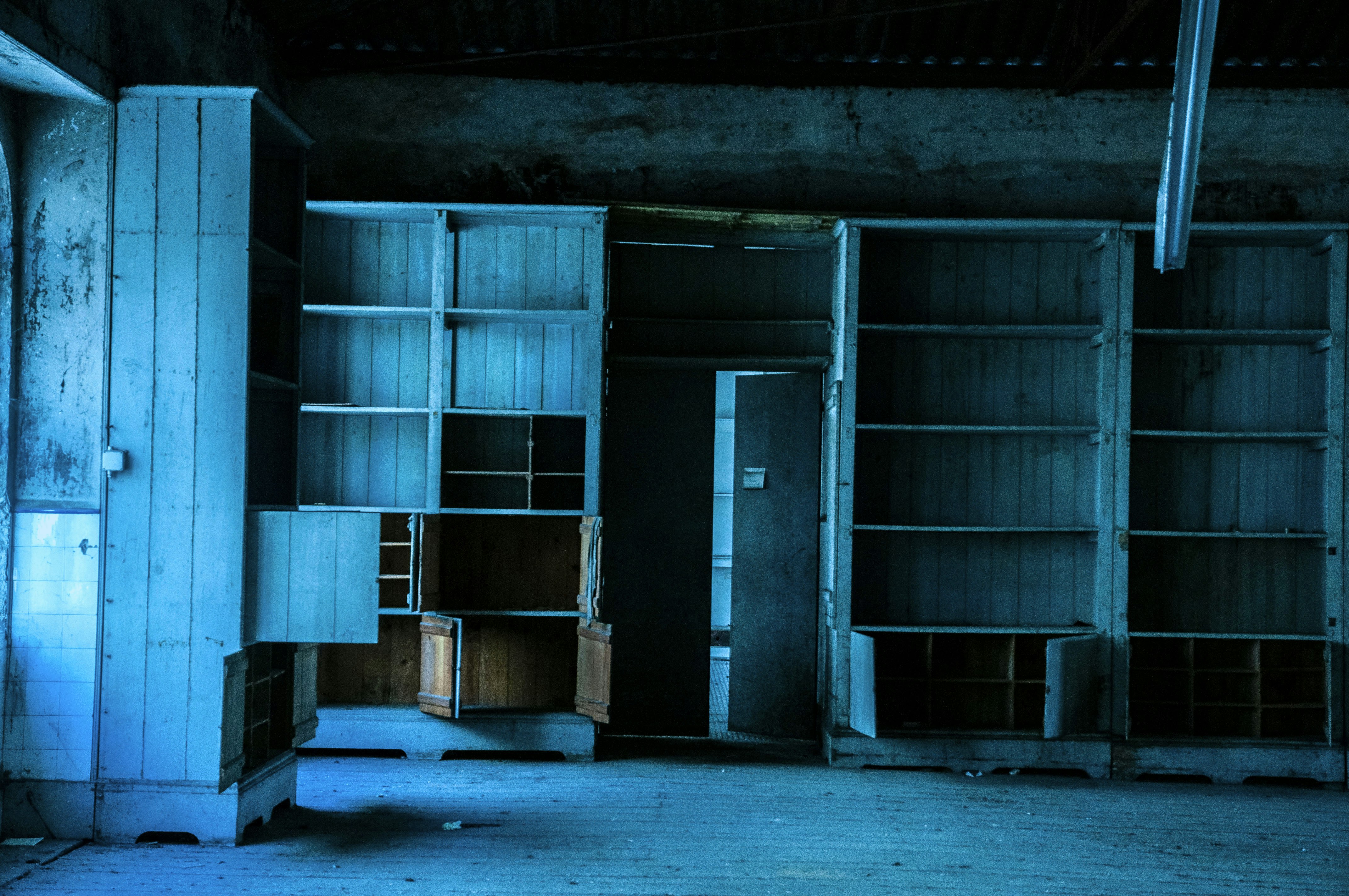 an empty room with a book shelf and a door