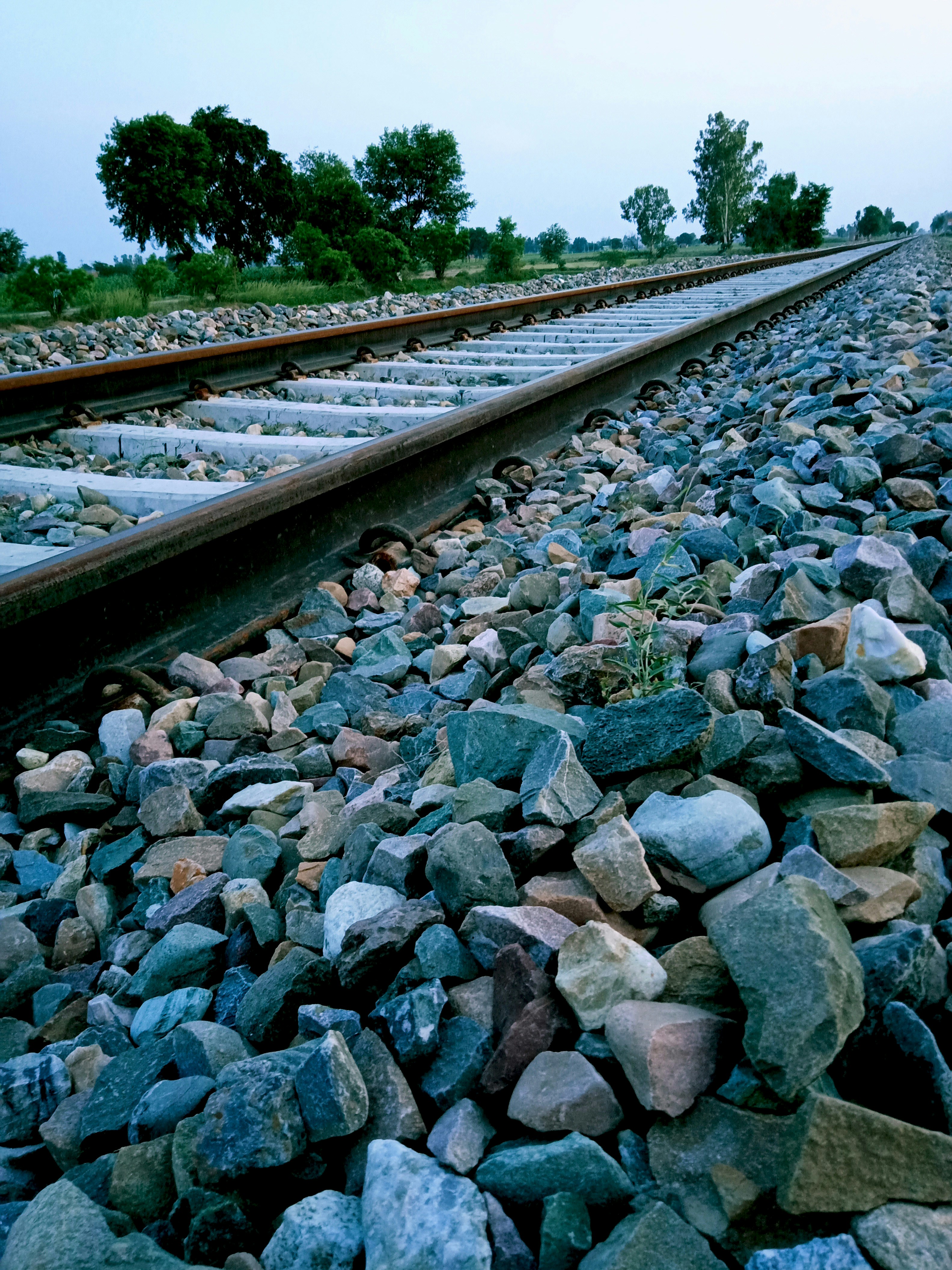A train track with rocks and grass next to it photo – Free Tarn taran ...