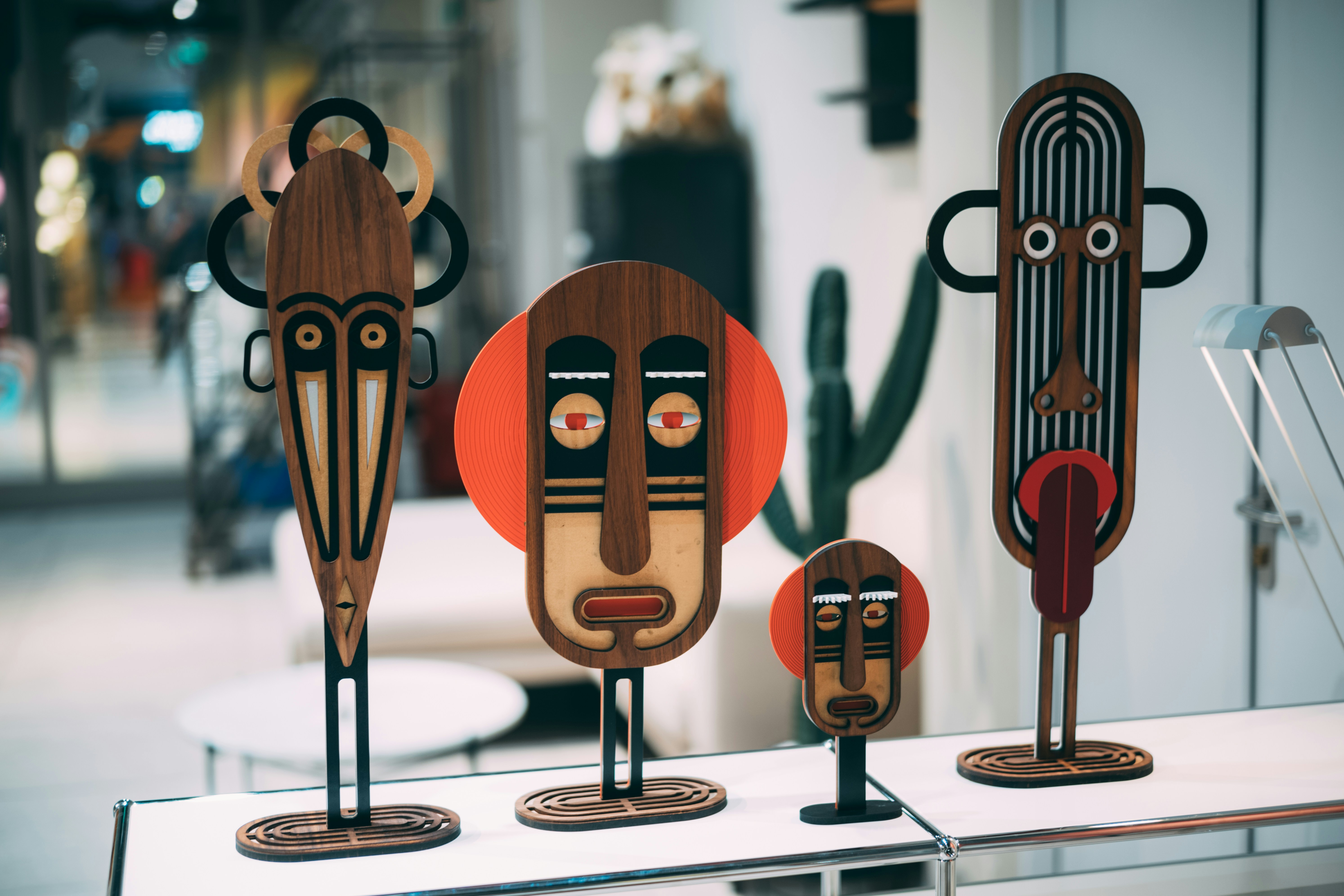 Wooden Faces on Display: A row of carved totems in a bright gallery