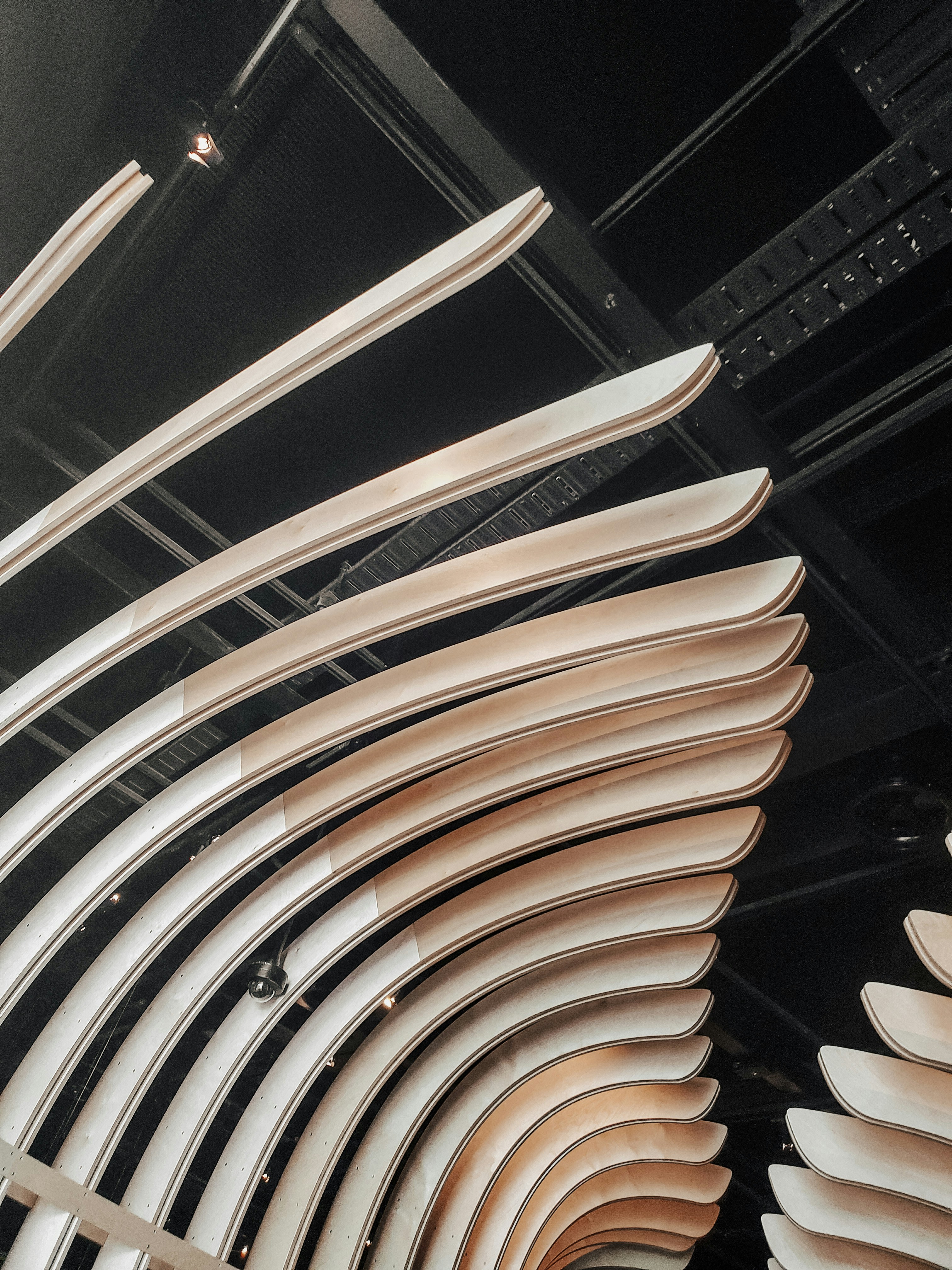 Abstract architectural elements showcasing a series of elegantly curved panels against a dark backdrop.